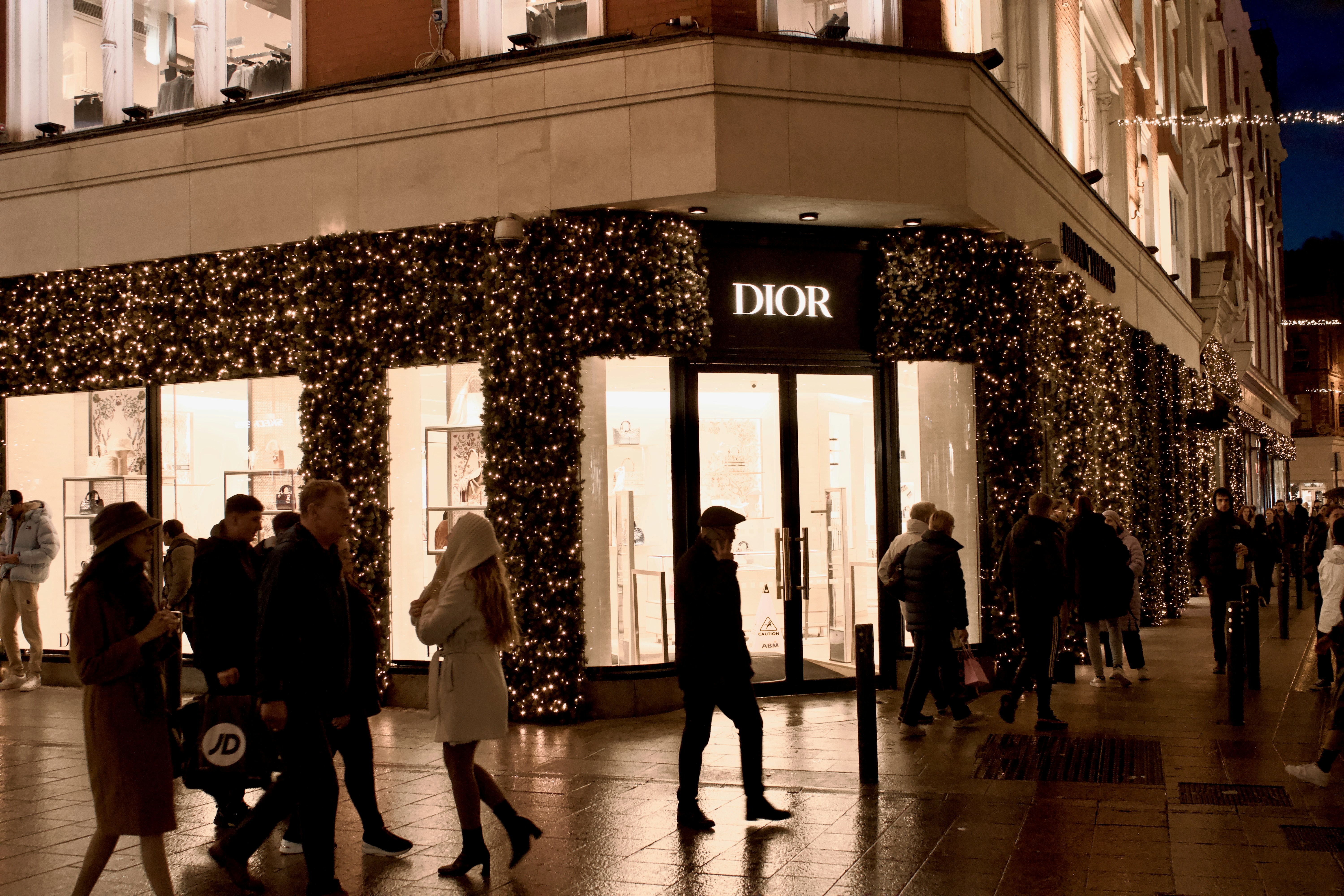 A dior storefront is illuminated at night. photo – Free Dior Image on ...