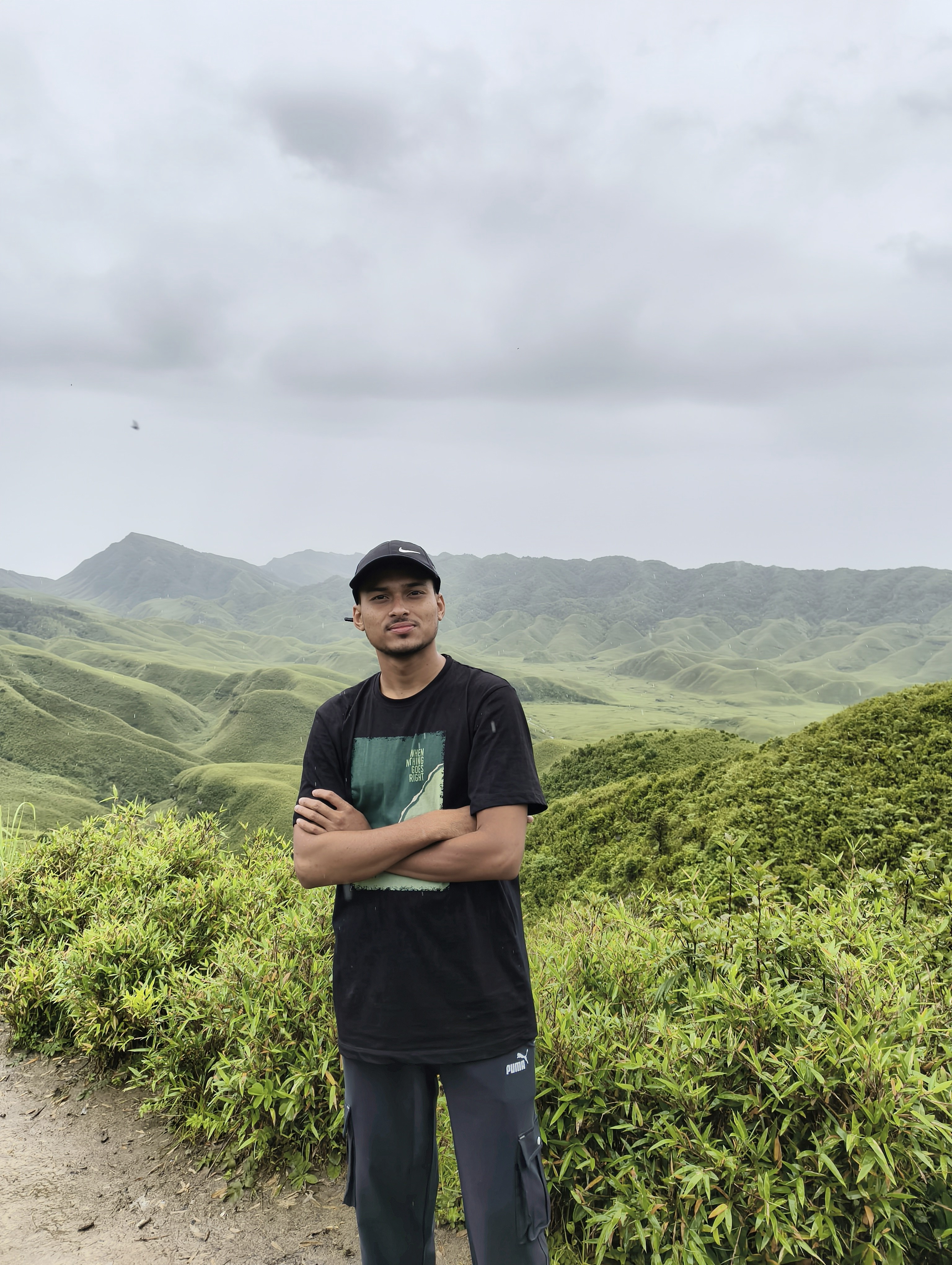 Crossed Arms Against Rolling Green Hills