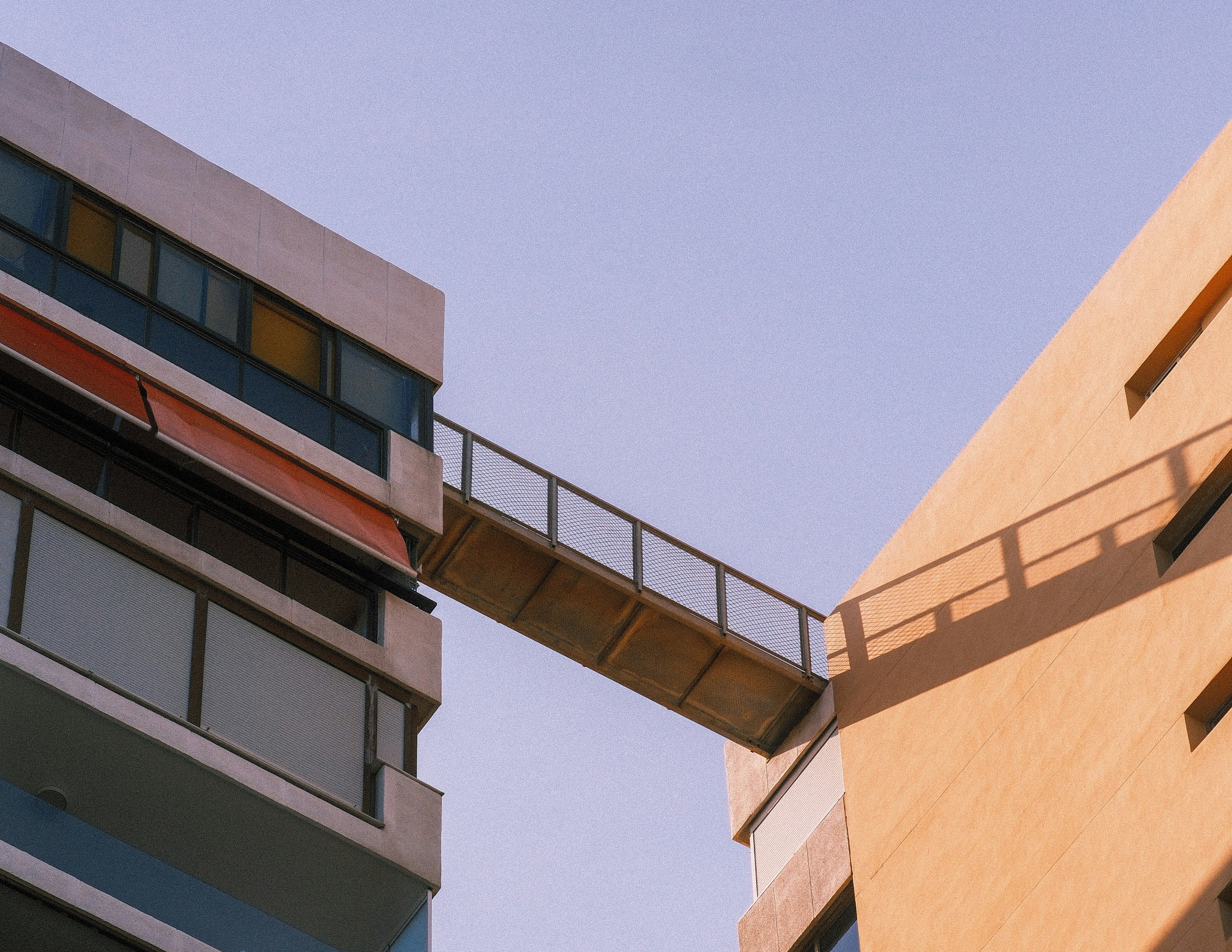 sky bridges. | A bridge connects two buildings under a clear sky.
