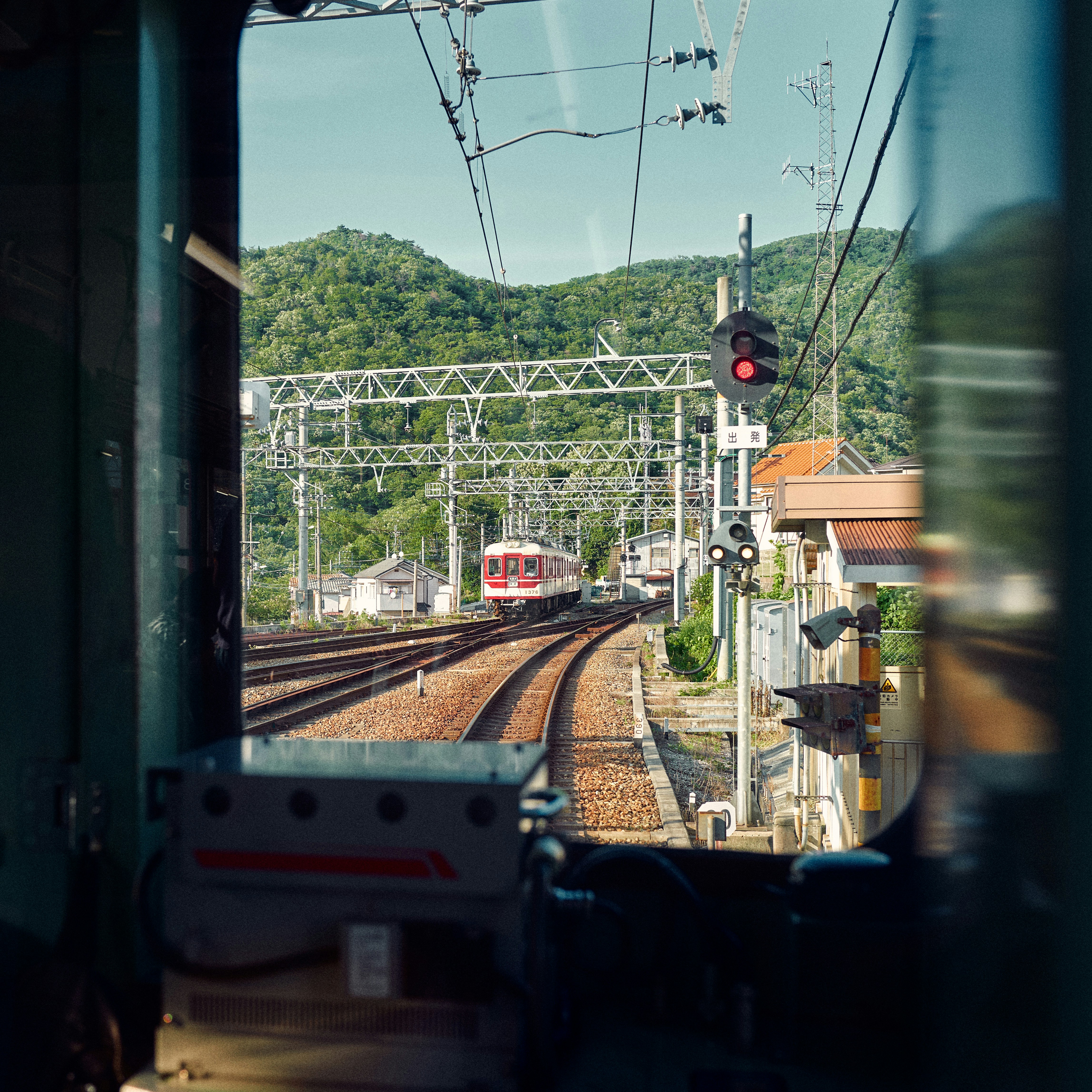 A quiet moment waiting for the next train — somewhere in rural Japan, framed through the driver’s cabin. | Train view from a train window.