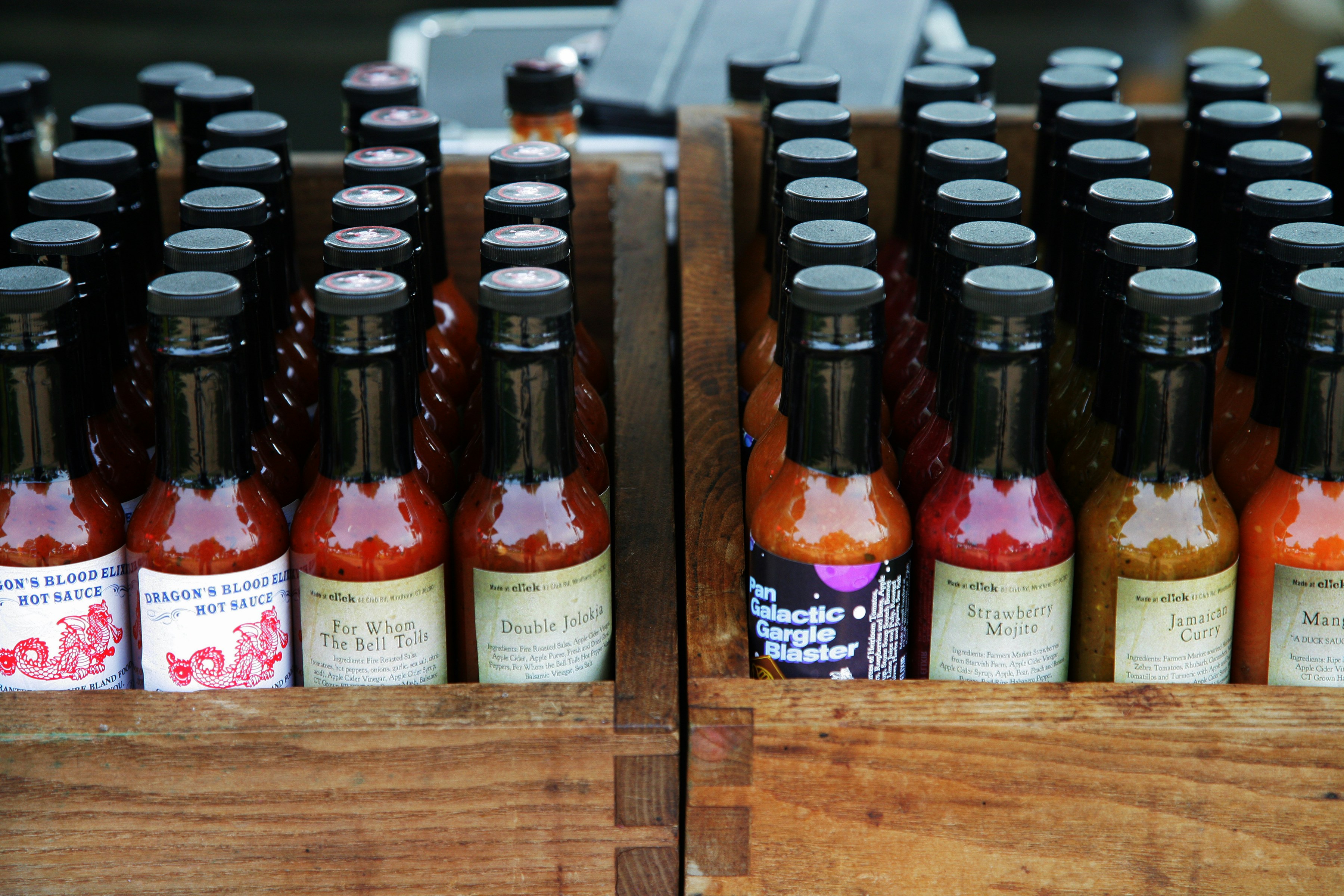 Ember Rows: A Rustic Palette of Hot Sauces on Wooden Shelves