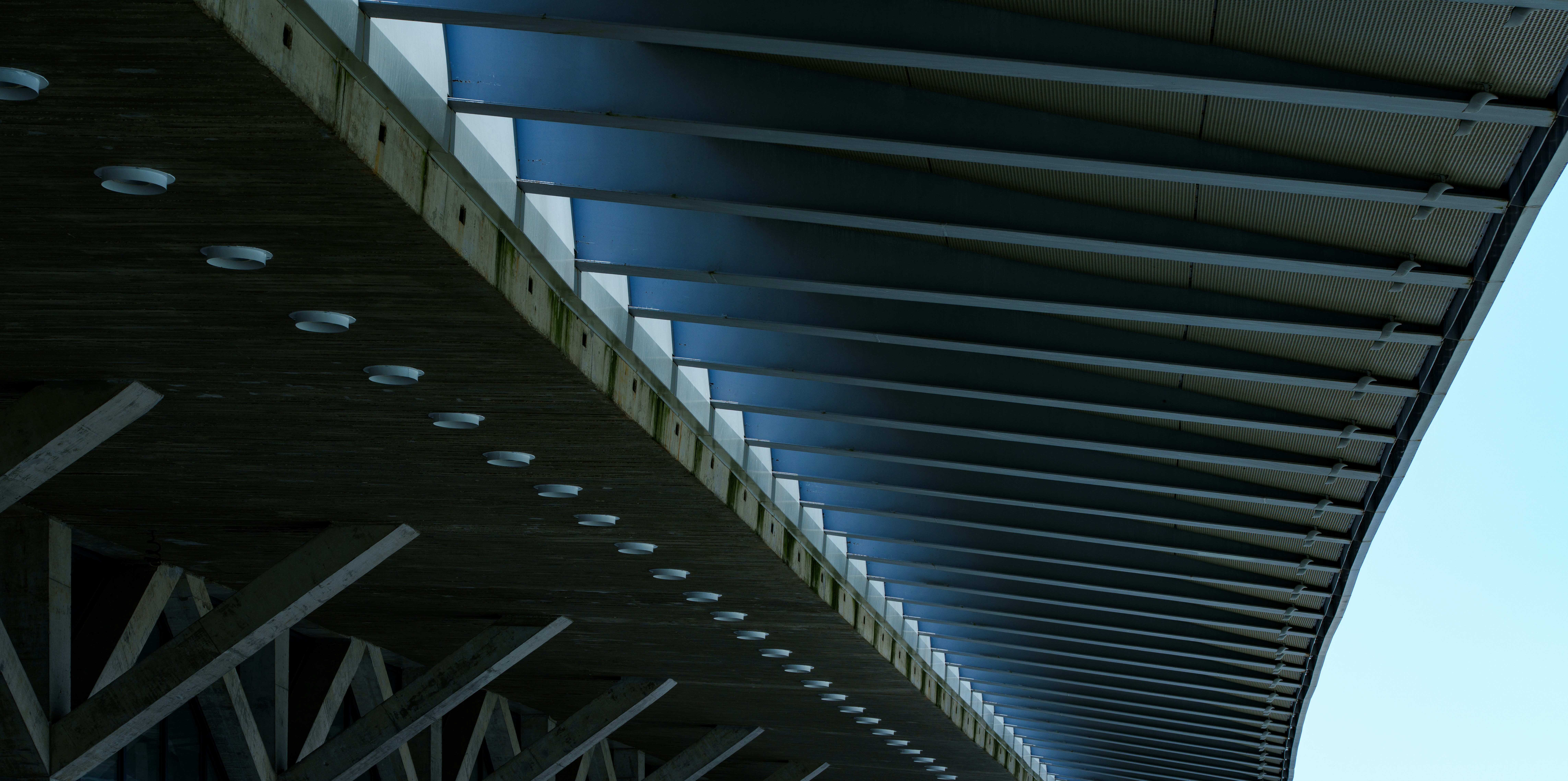 Innovative roof structure with geometric lines and circular lights, showcasing modern architectural design.