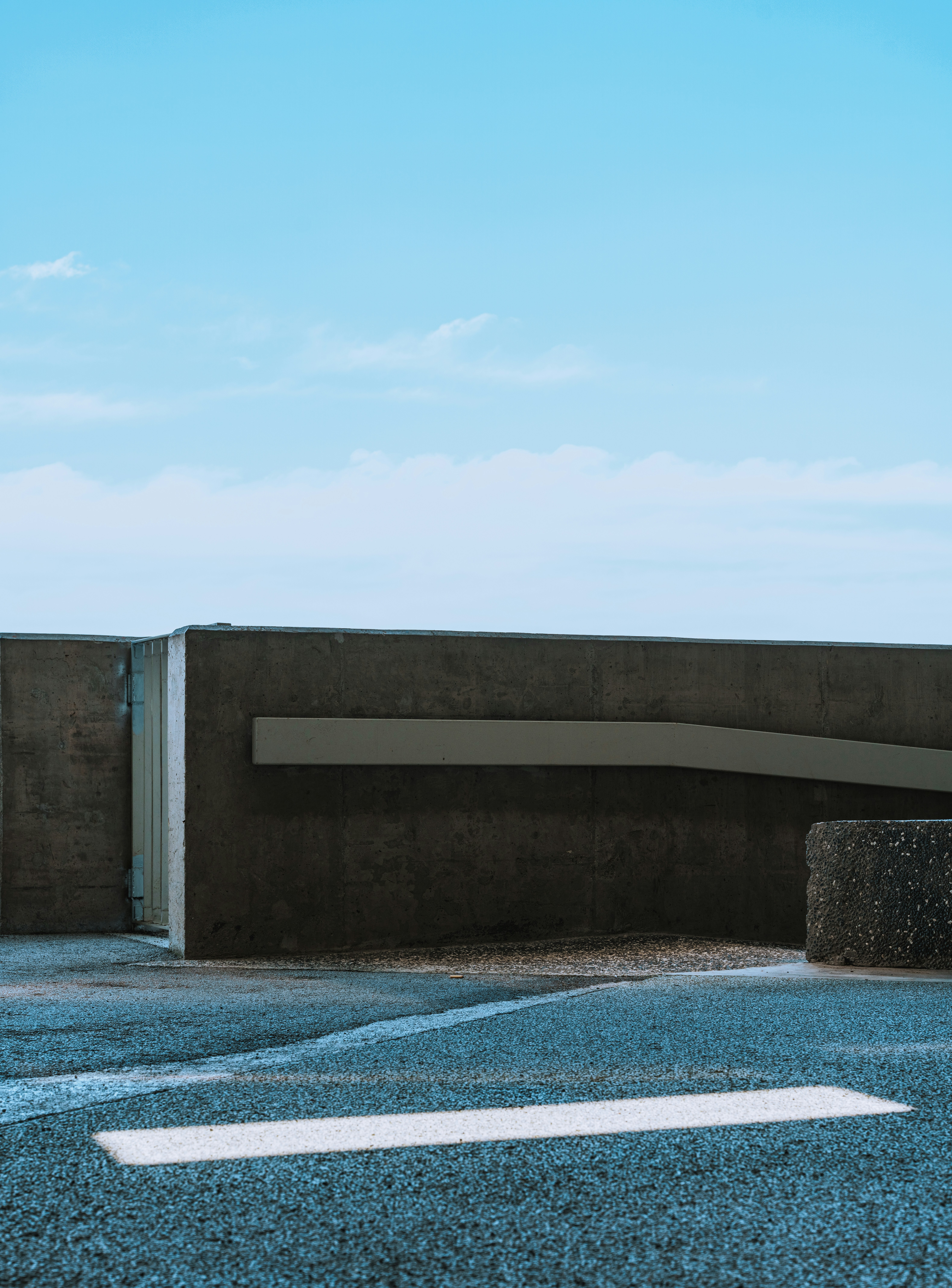 A sleek concrete structure meets a clear blue sky, showcasing modern architectural lines and a serene atmosphere.