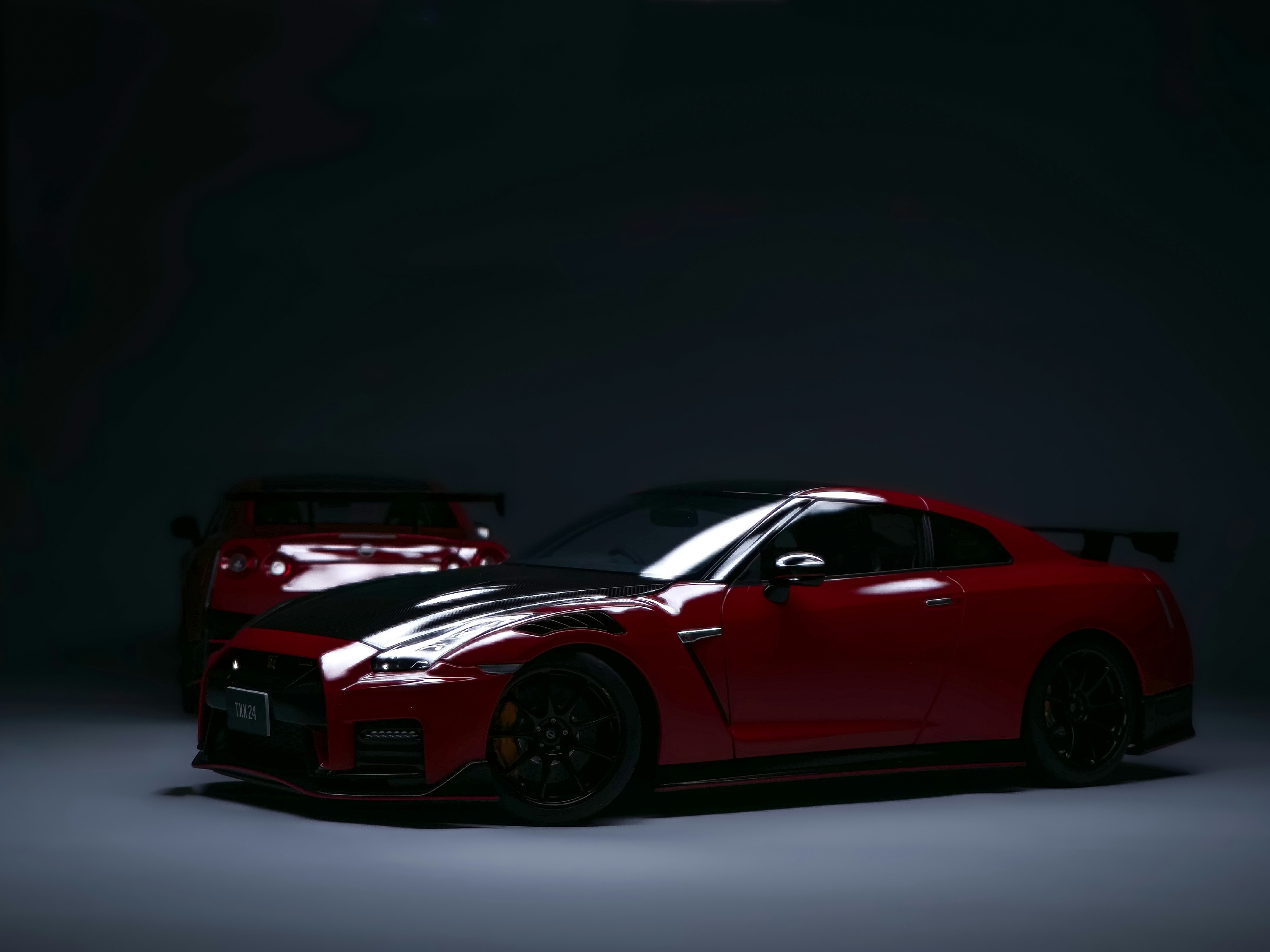 A red nissan gt-r is displayed in the darkness. photo – Free Car Image ...