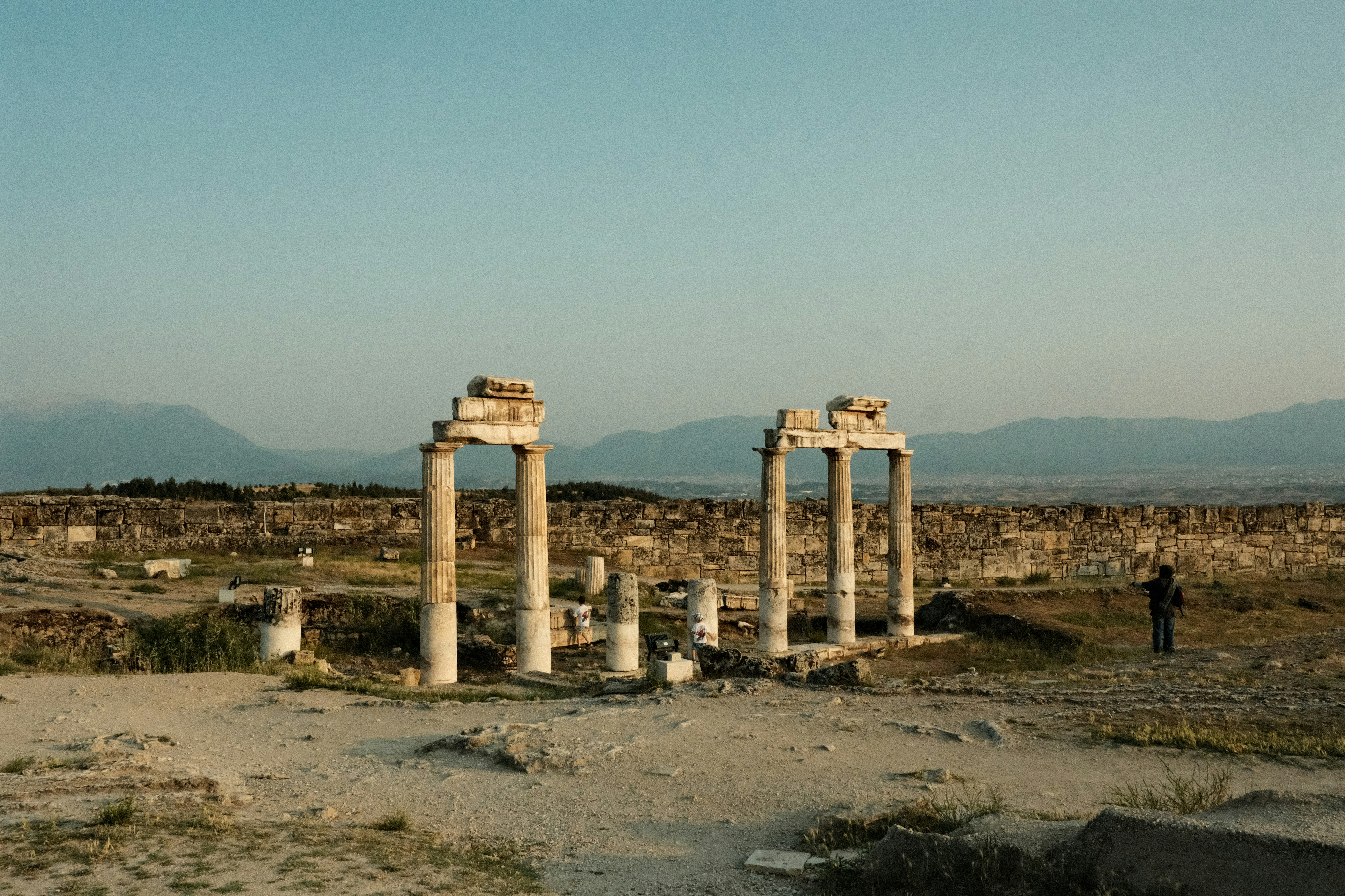 Ancient ruins stand against a serene, clear sky.