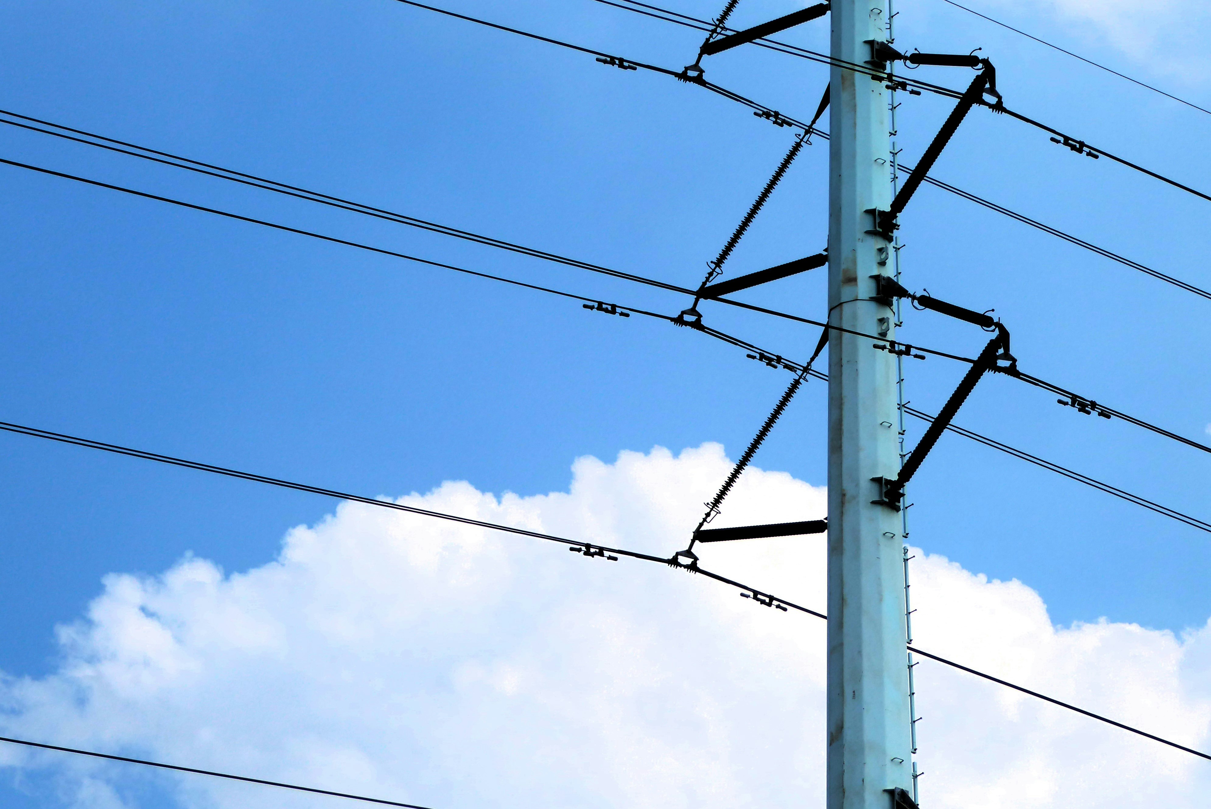 Power lines and a utility pole against blue sky.