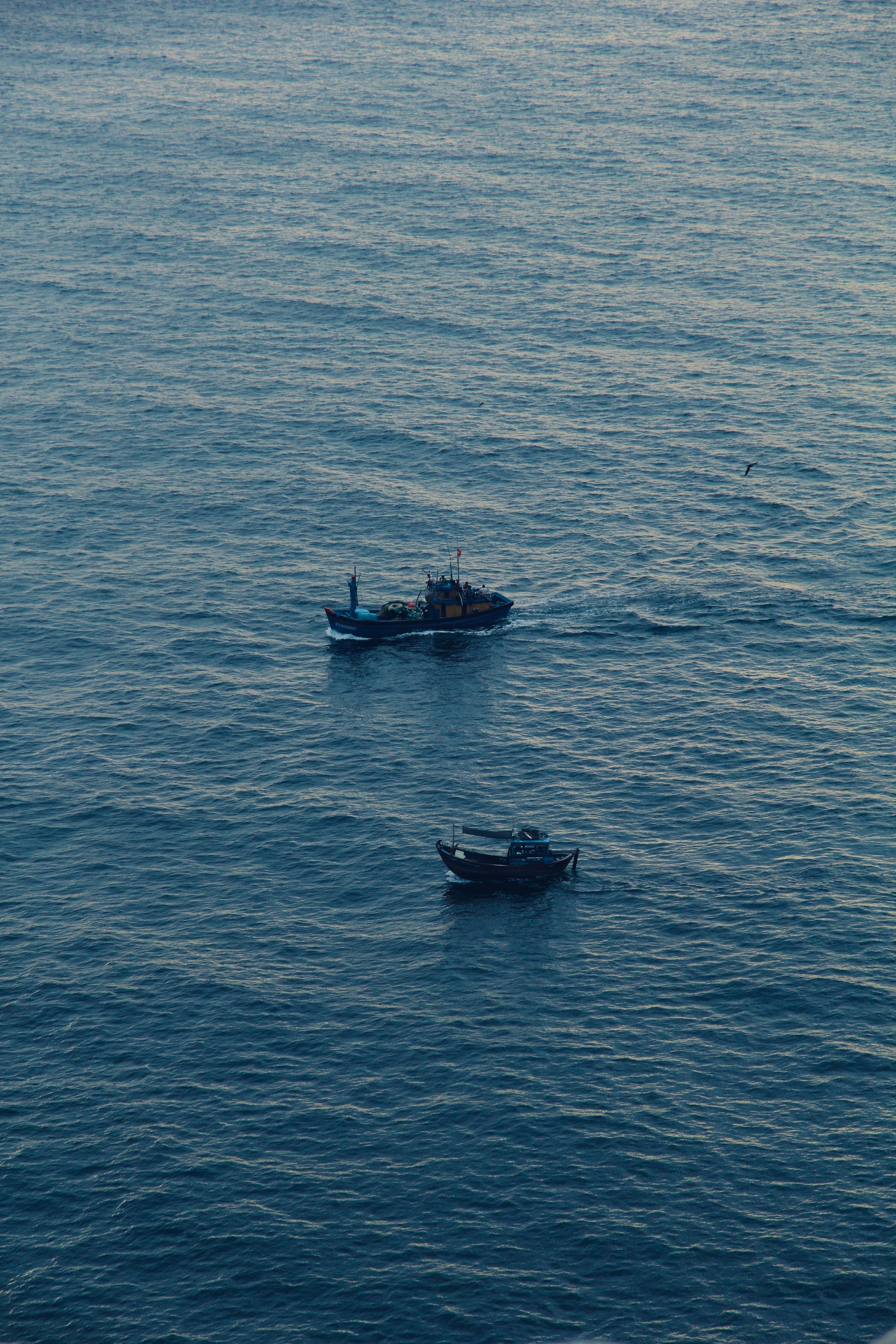 “Majestic tranquility”. | Two boats are sailing on the calm ocean.