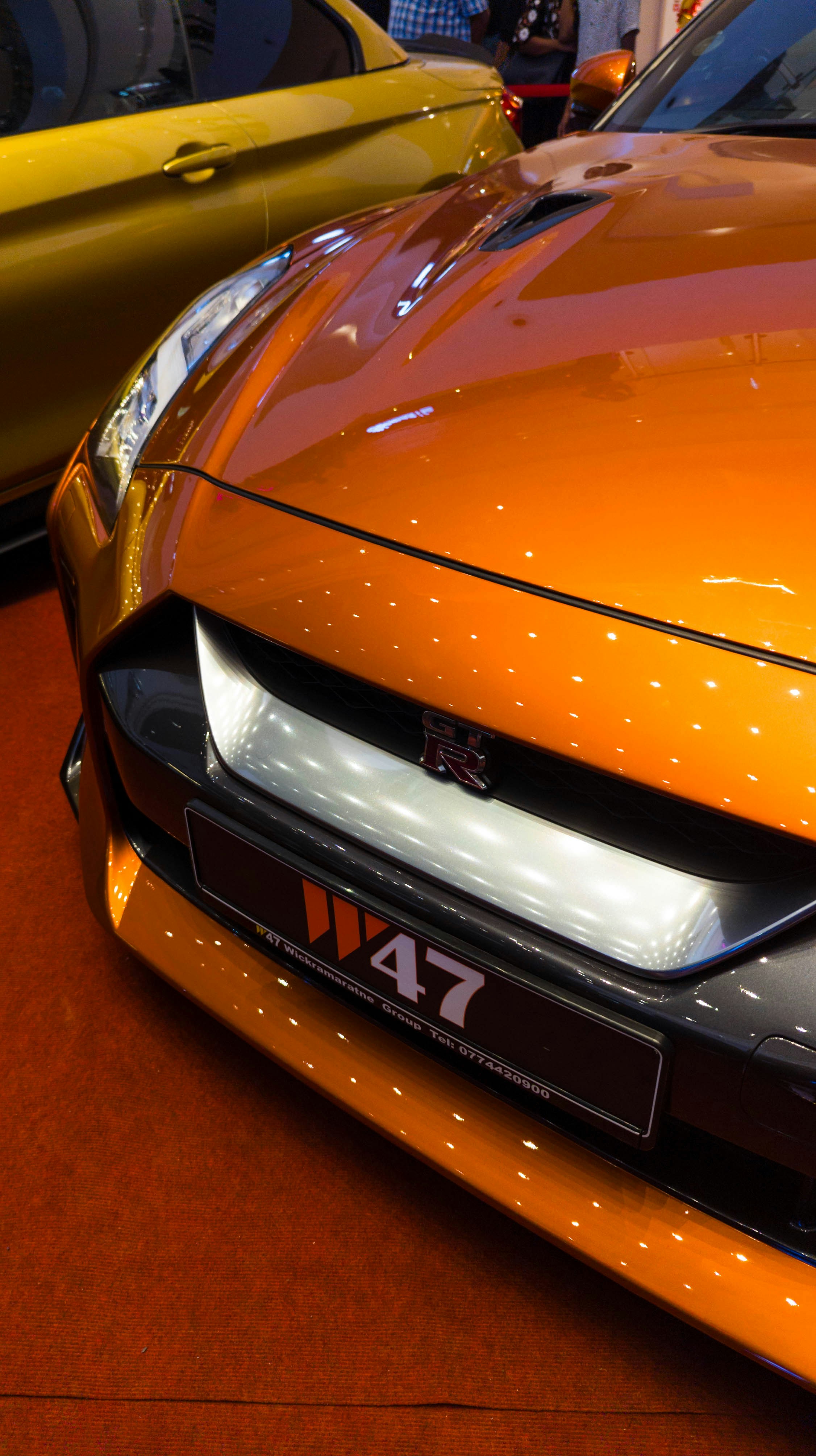 Close-up of an orange Nissan GT-R at a glossy showroom display