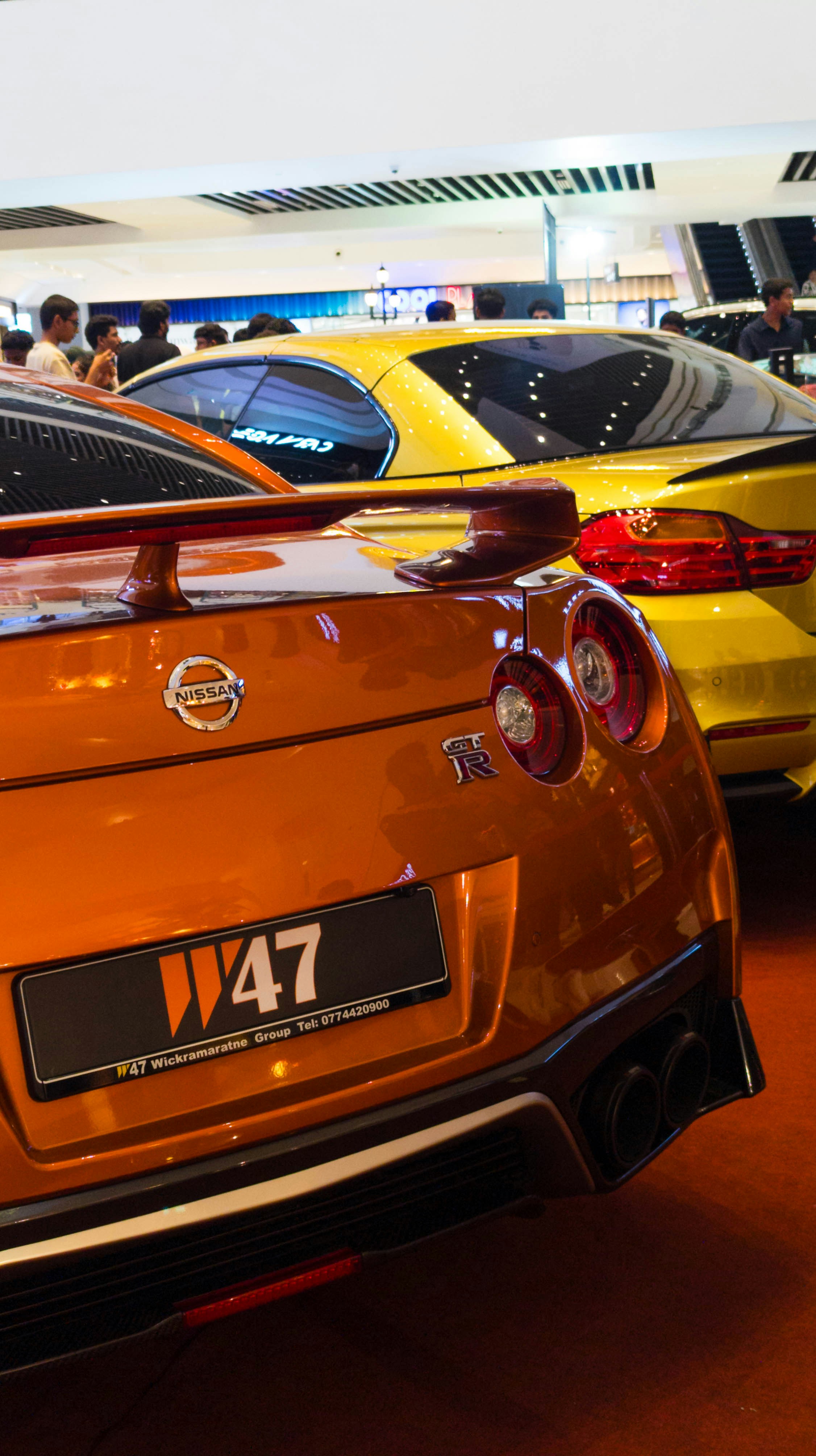 Rear-Quarter Power: An Orange Nissan GT-R Anchors a Showroom Scene