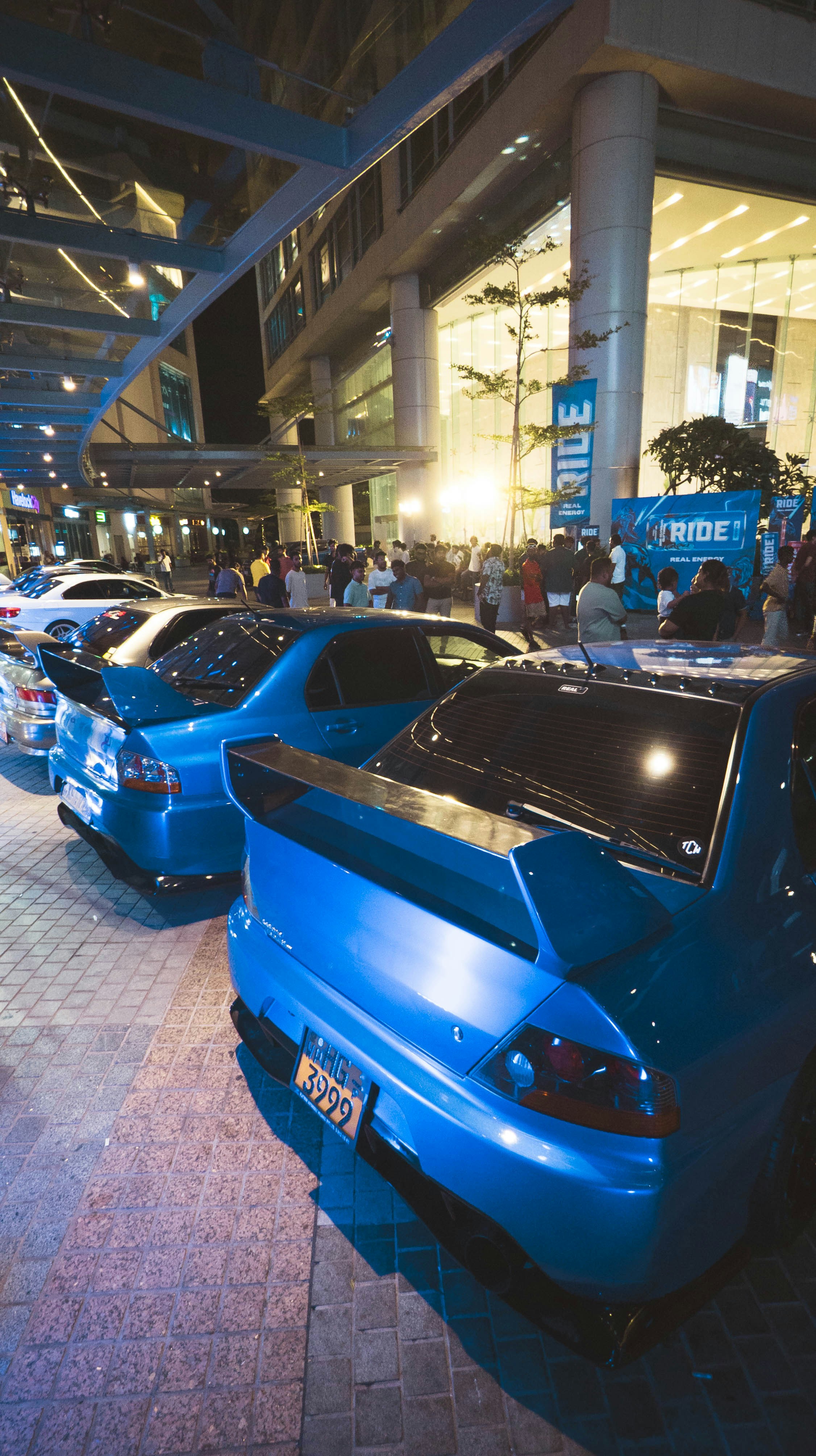 Dynamic rear perspectives of the Lancer Evolution, showcasing its signature spoiler and taillight design under the night sky. | Blue cars at night.
