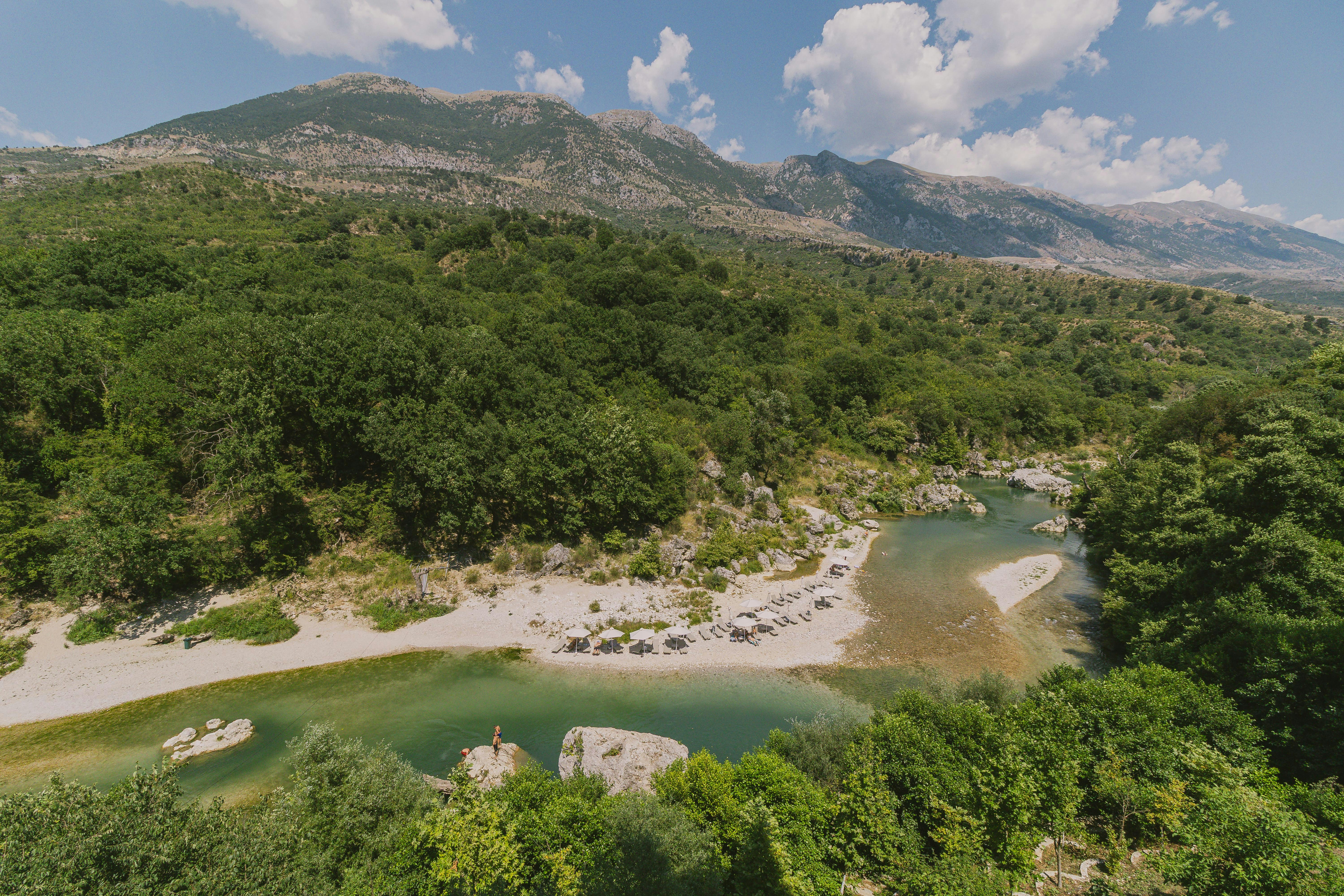 A lush river flows through a mountainous landscape. photo – Free ...