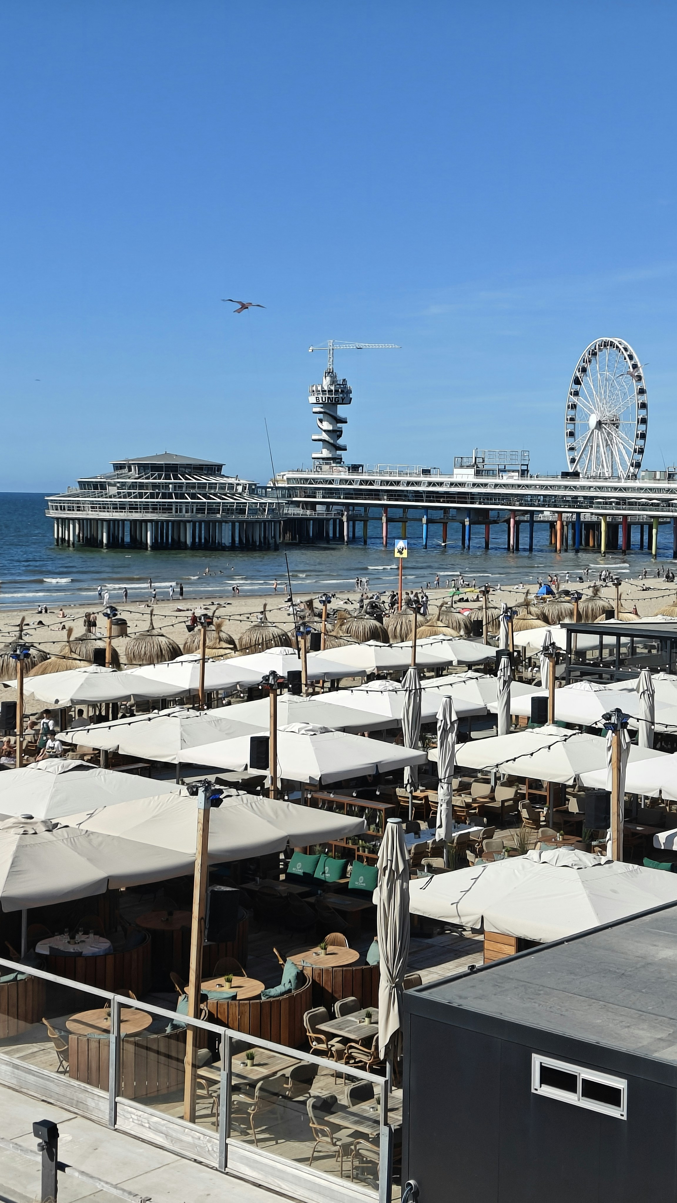 Pier Scheveningen and some beach restaurants | Beach with a pier, restaurants and a ferris wheel.