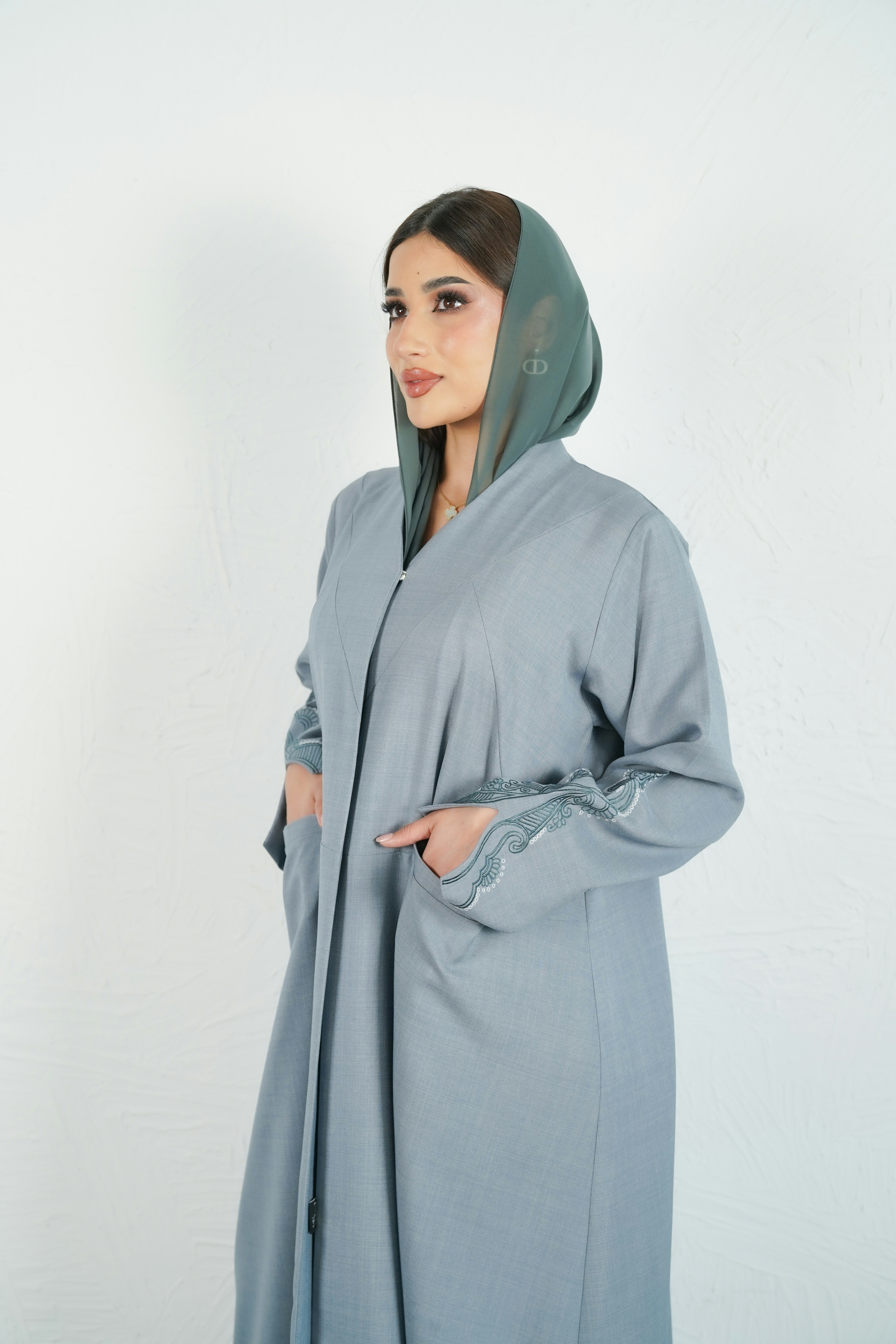 Woman wears a beautiful gray abaya with a headscarf.