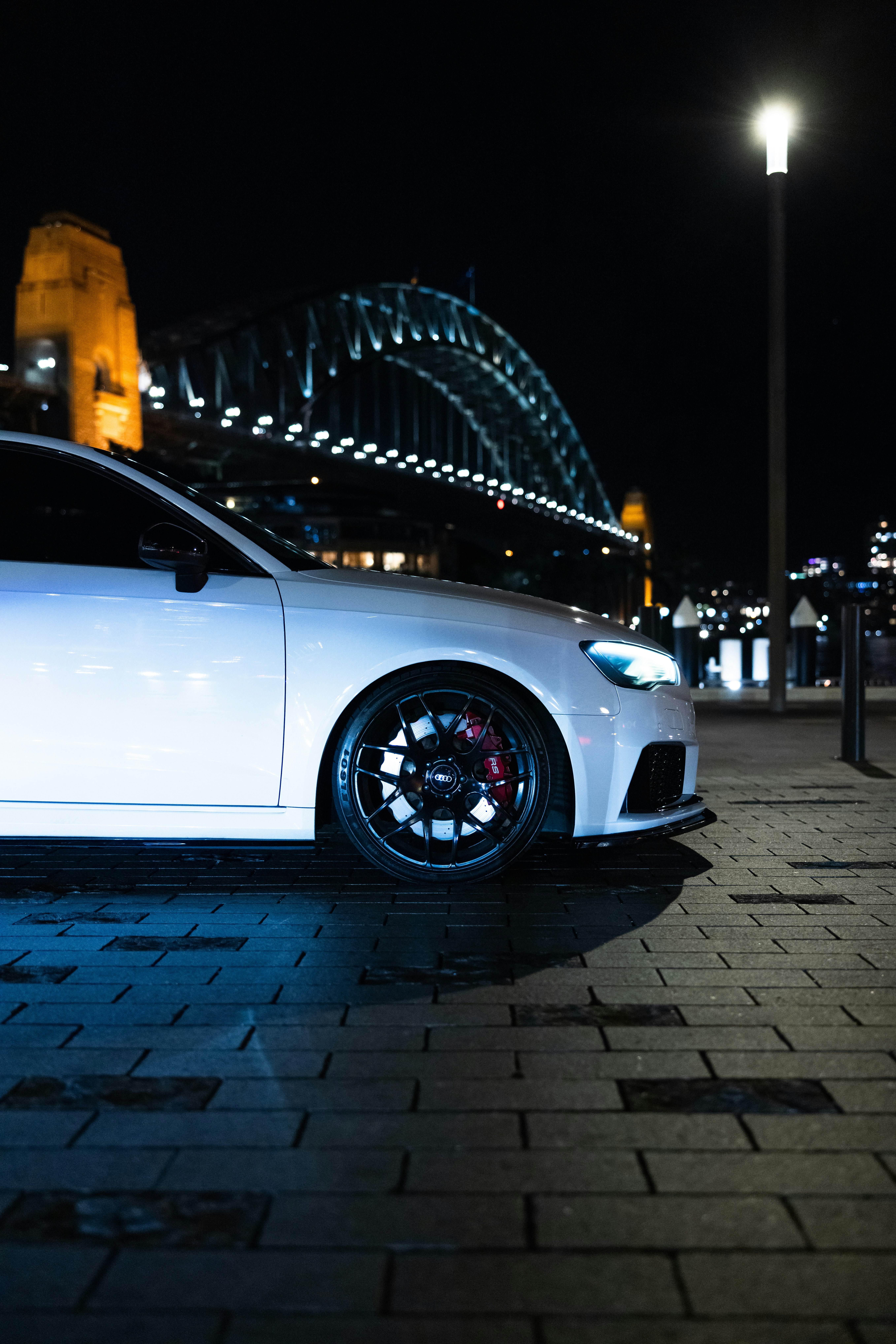 Night Wheel by Neon Bridge: A White Sport Sedan Under City Lights