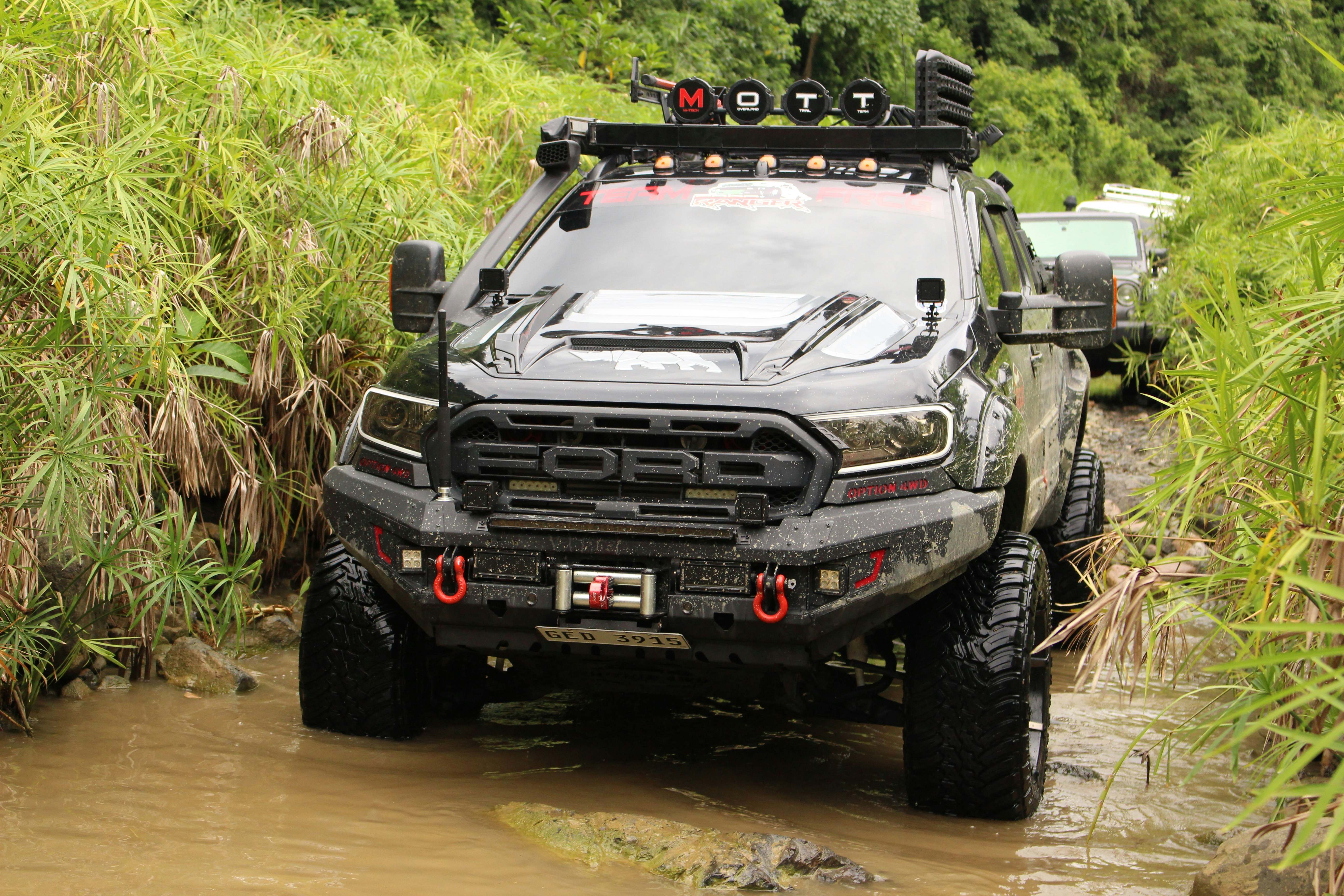 Mud-Splashed Frontline: A Bold Off-Roader Tackles a Muddy Creek