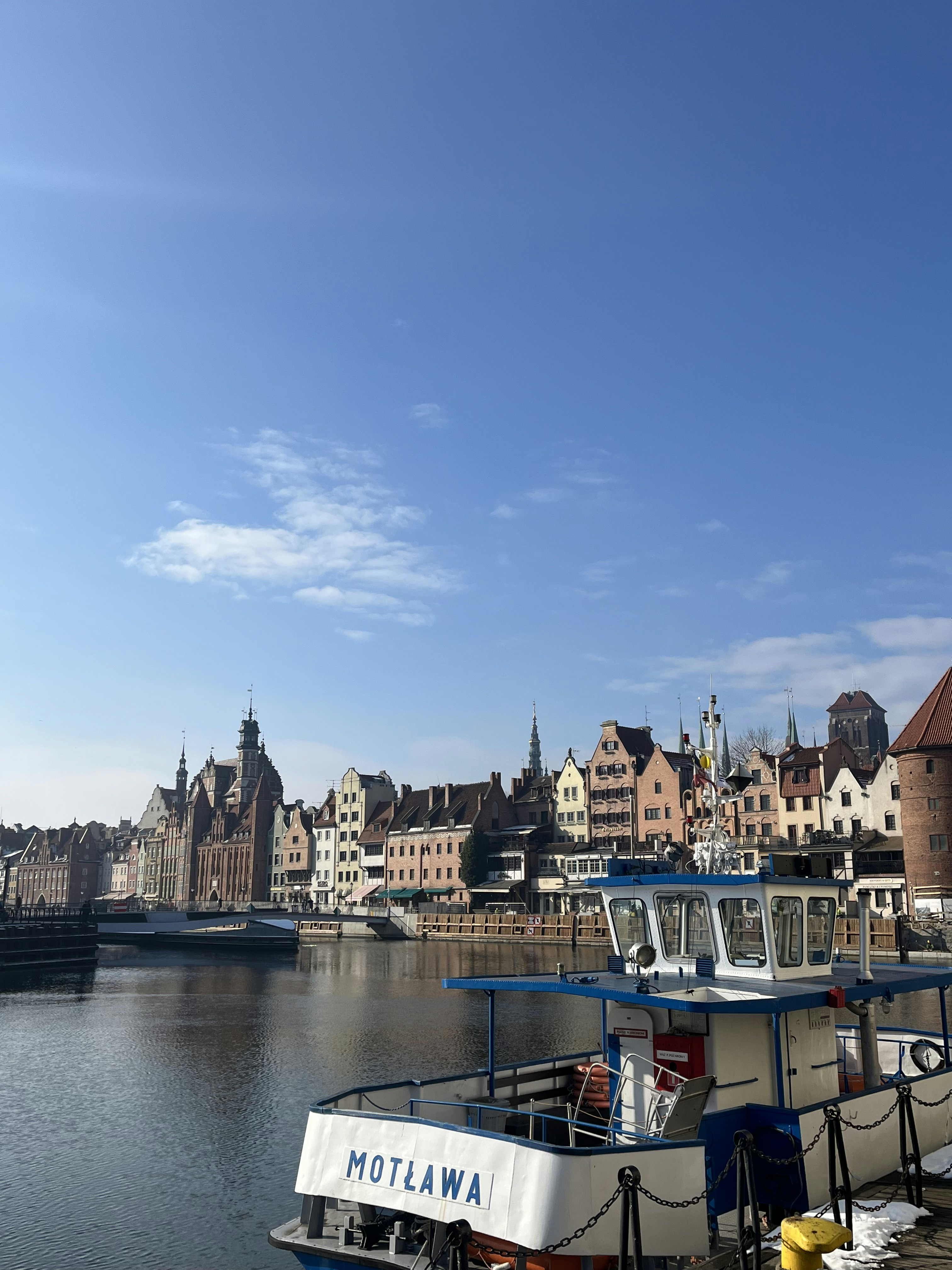 A boat on the water with a historic city.