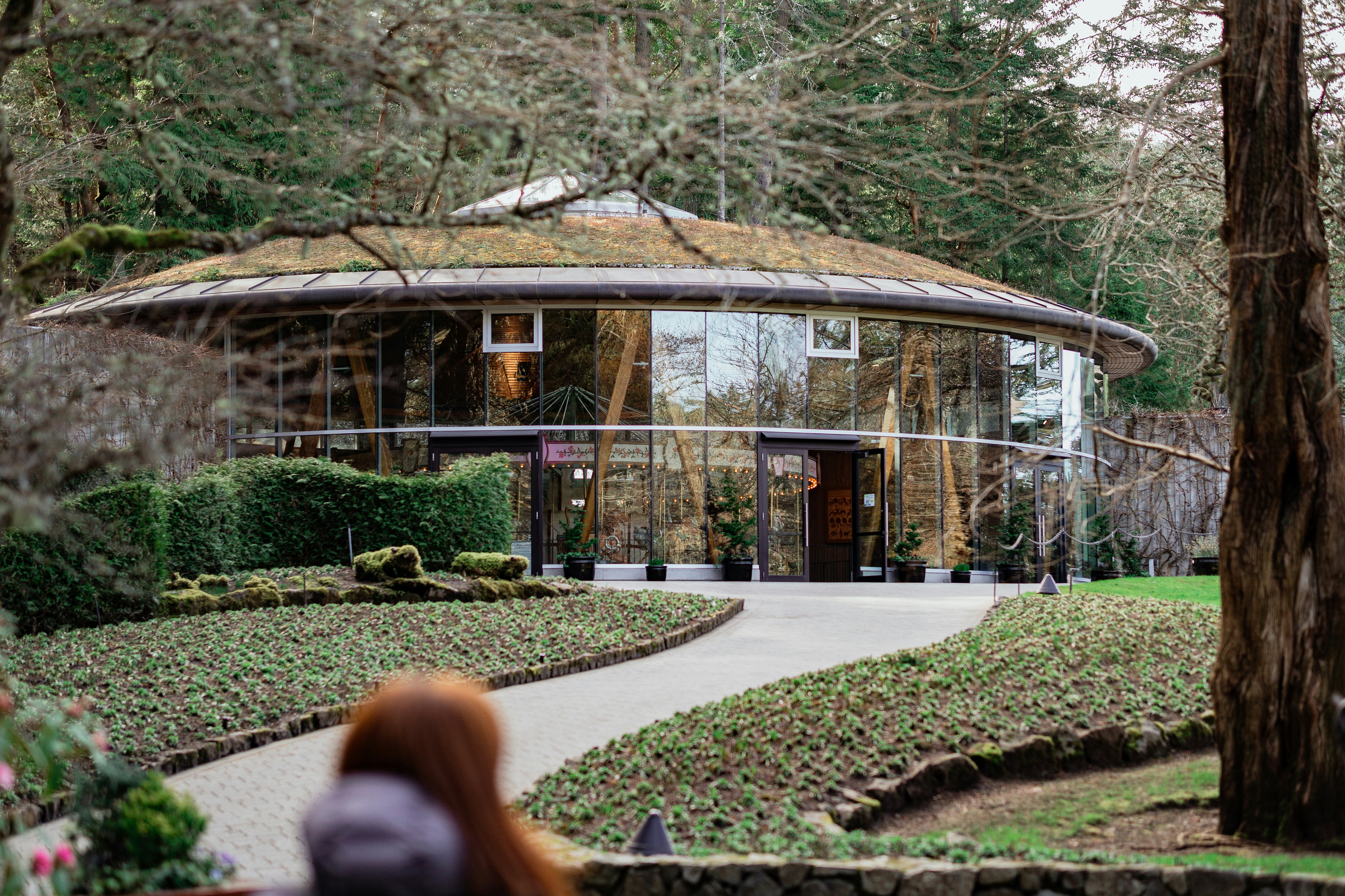 Modern glass structure nestled in a lush garden, showcasing a seamless blend of nature and contemporary design.