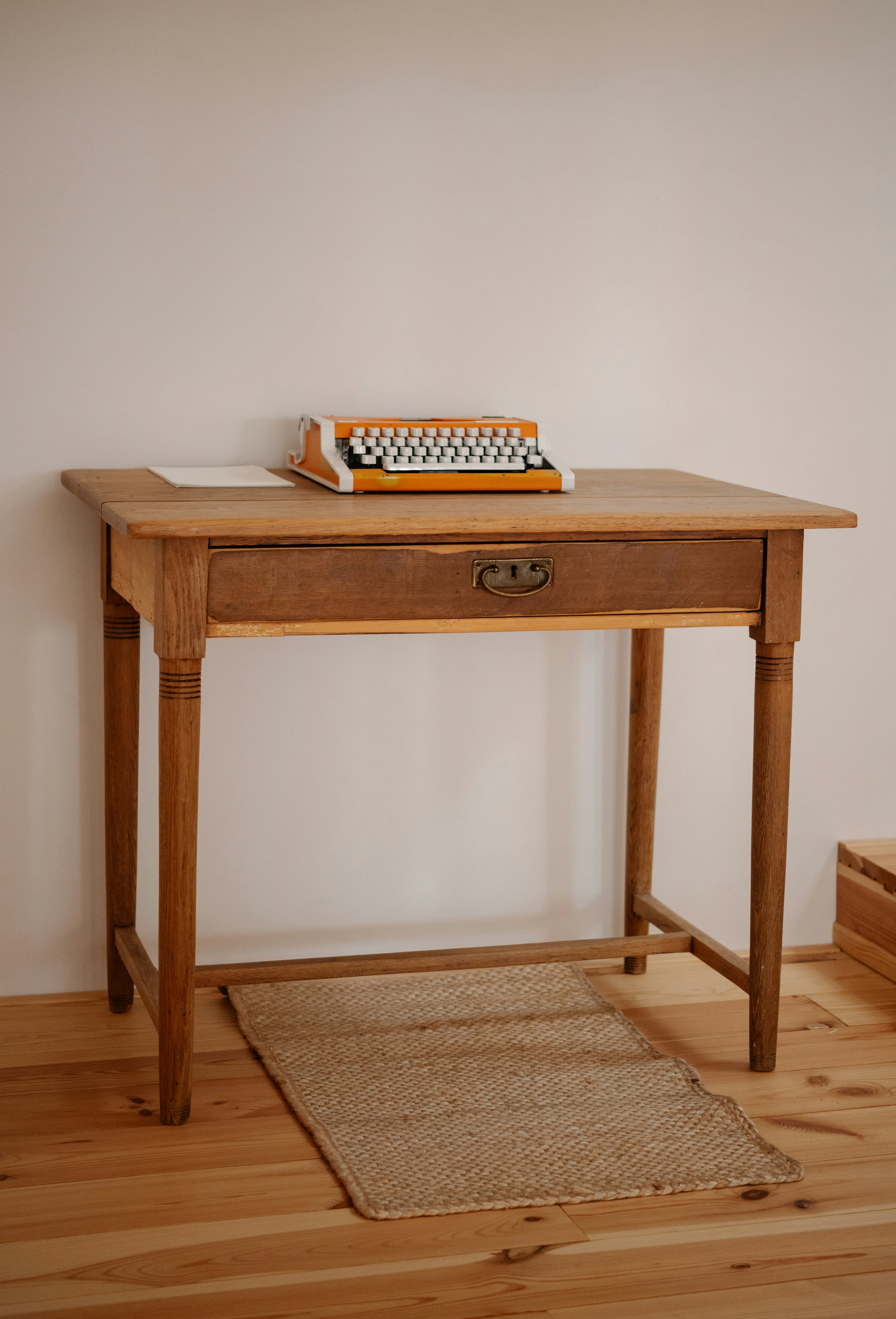 A vintage typewriter sits atop a wooden desk.