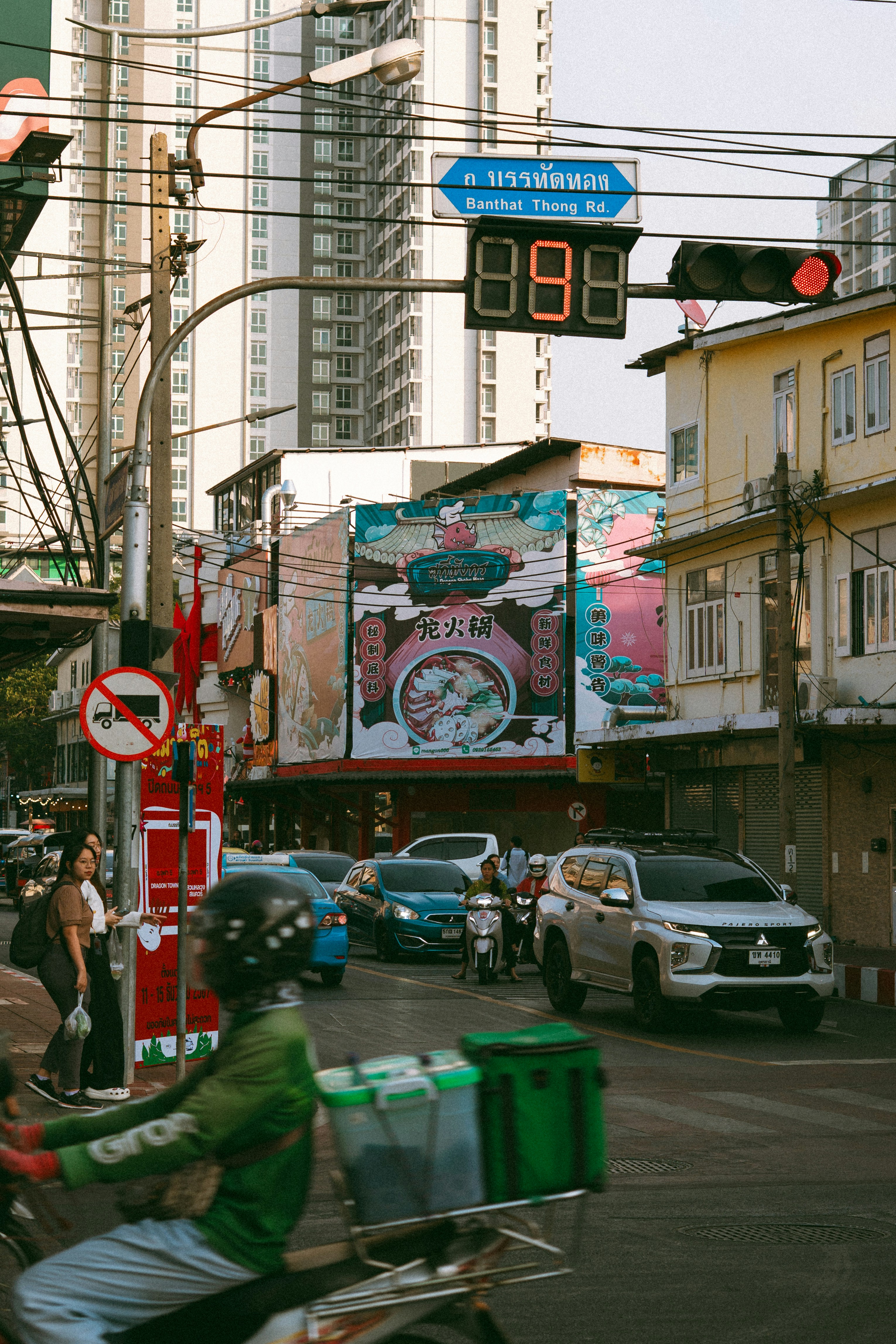 Vibrant street scene showcasing bustling traffic and colorful storefronts in an urban setting.