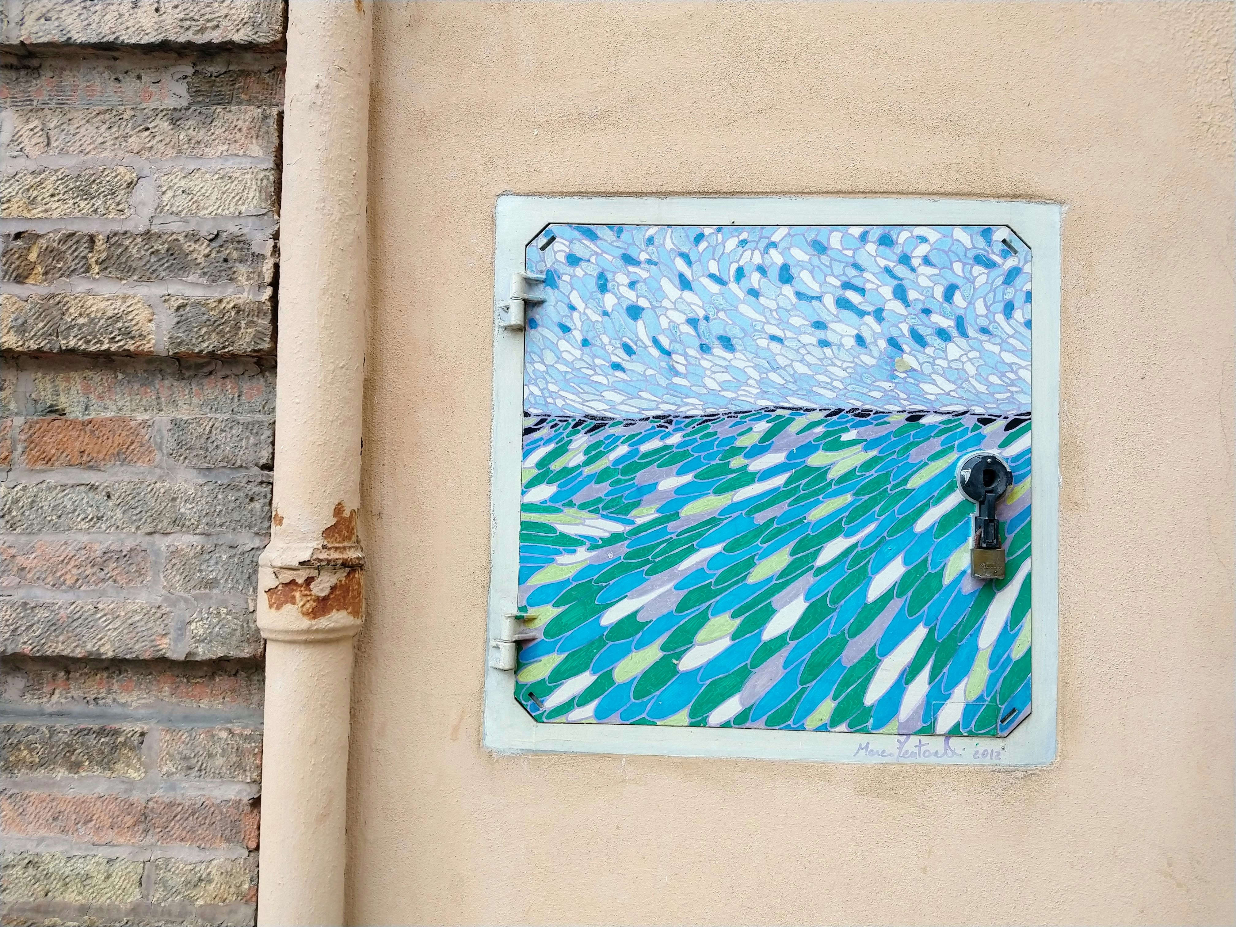 Colorful mural depicting abstract waves and sky, blending shades of blue and green. The artwork is framed within a utility box on a textured wall.