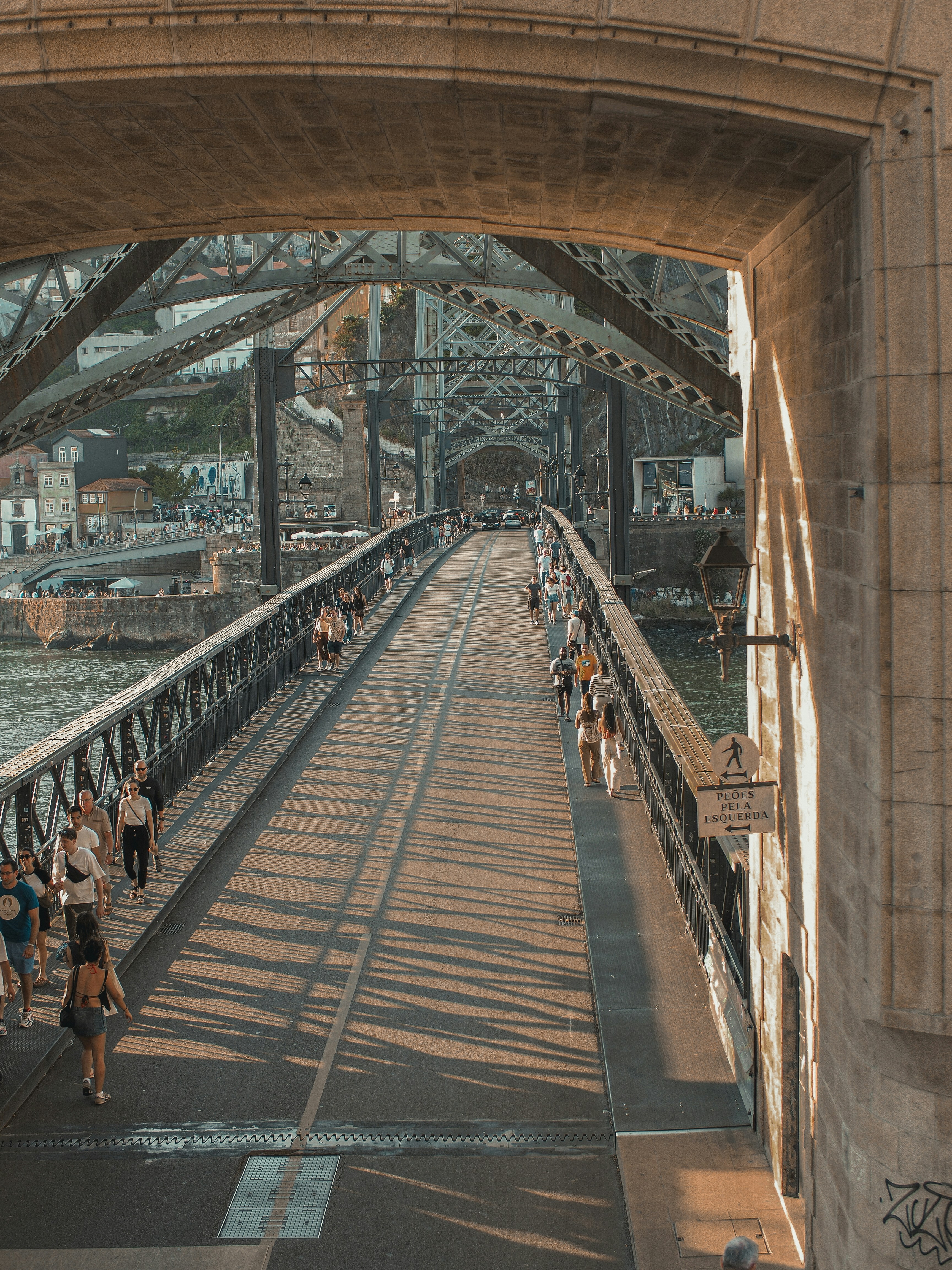 Pedestrian Span: Light and Shadow on the Lisbon Bridge Corridor