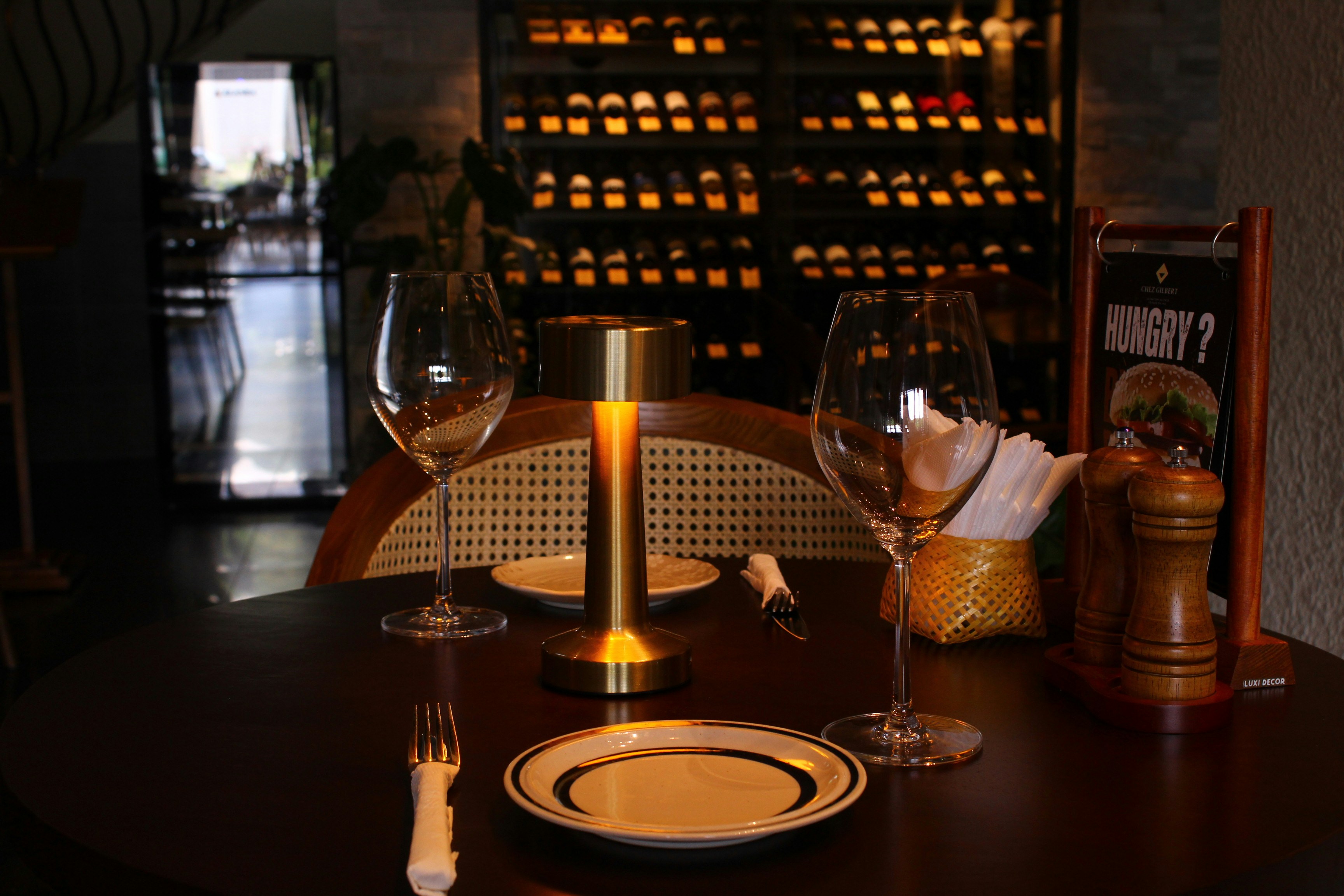 Chez Gilbert Saigon - French Bistro | Table setting in a restaurant with wine glasses.