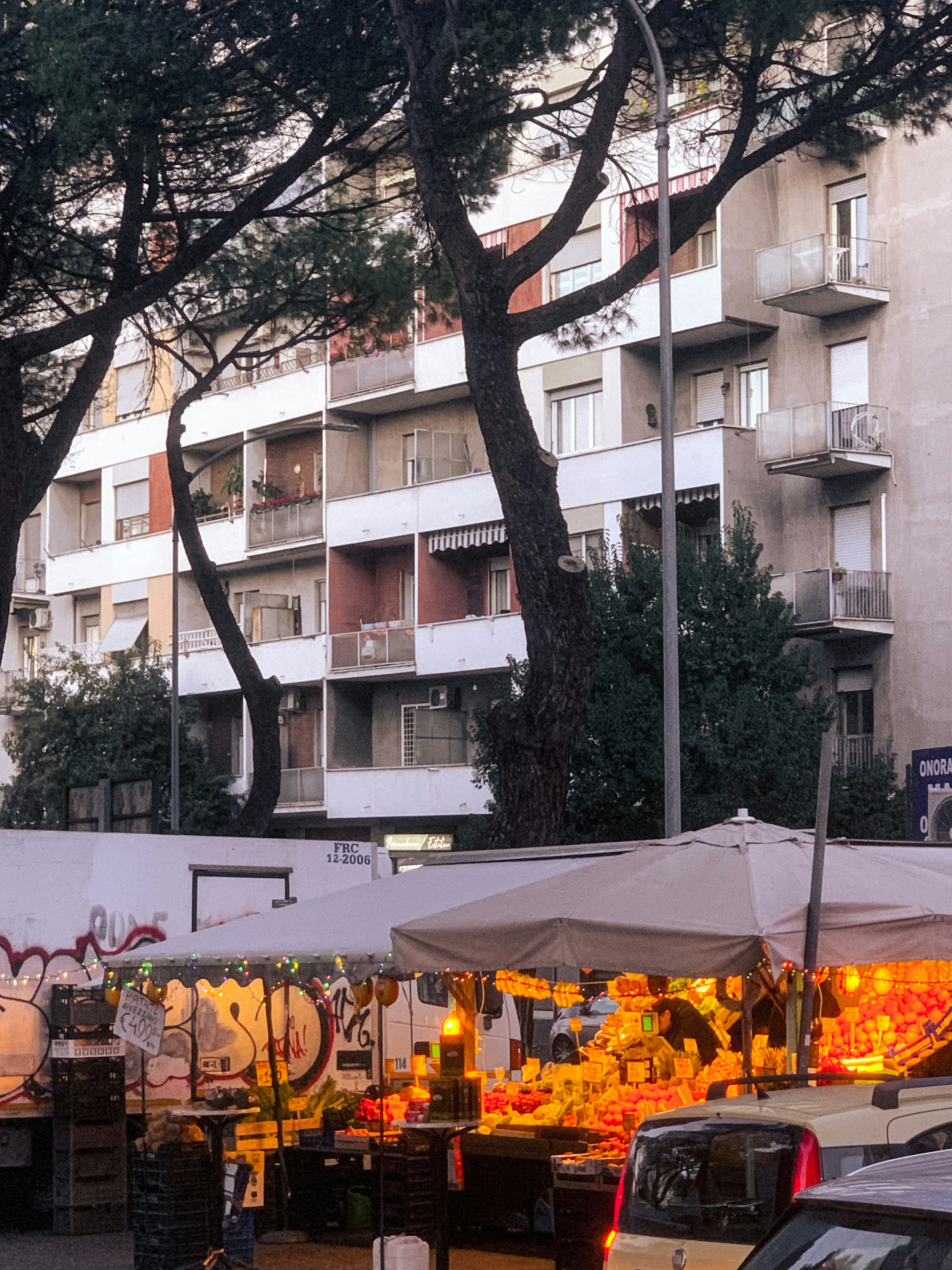A fruit market under apartment buildings.