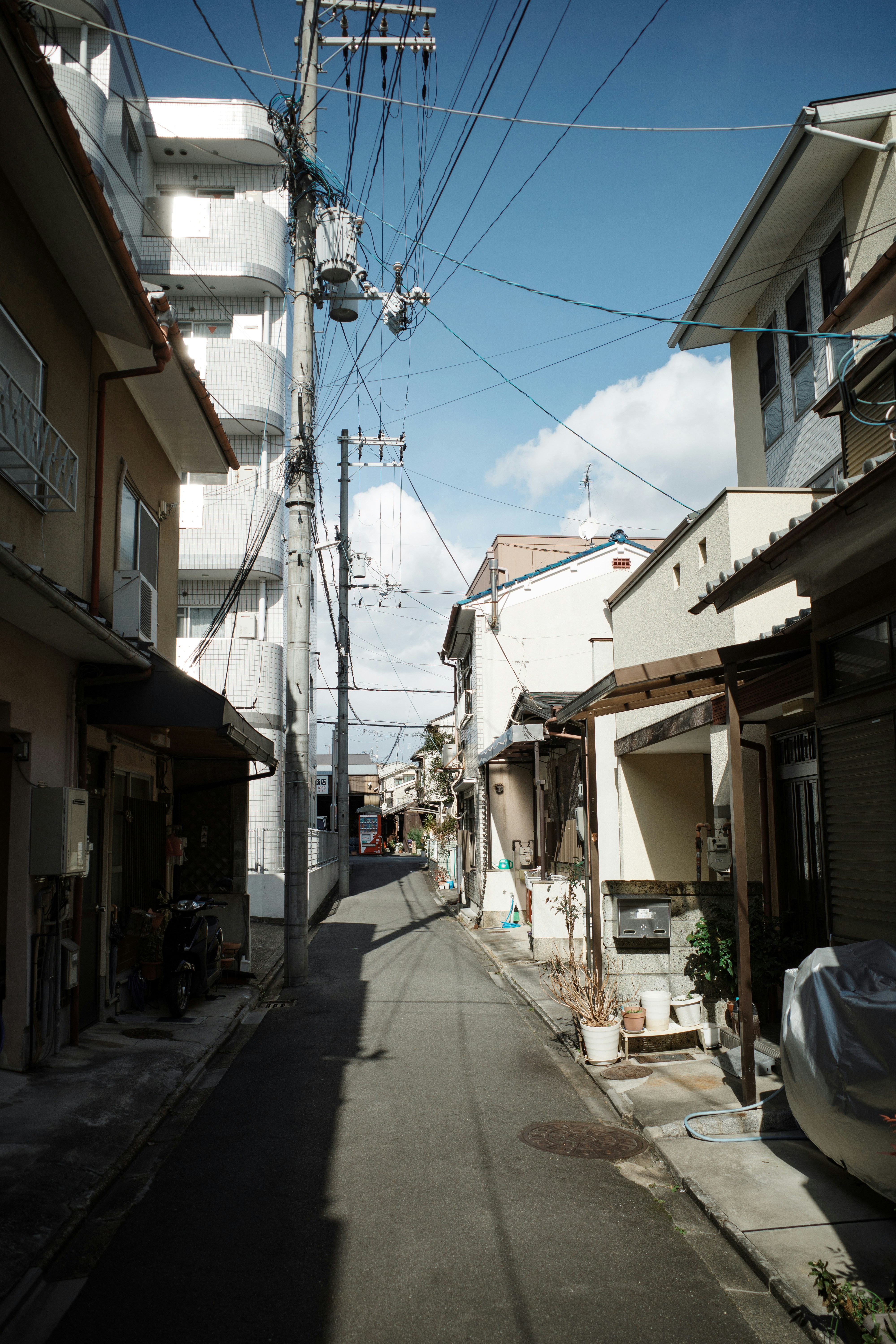 A narrow street leads into a neighborhood.