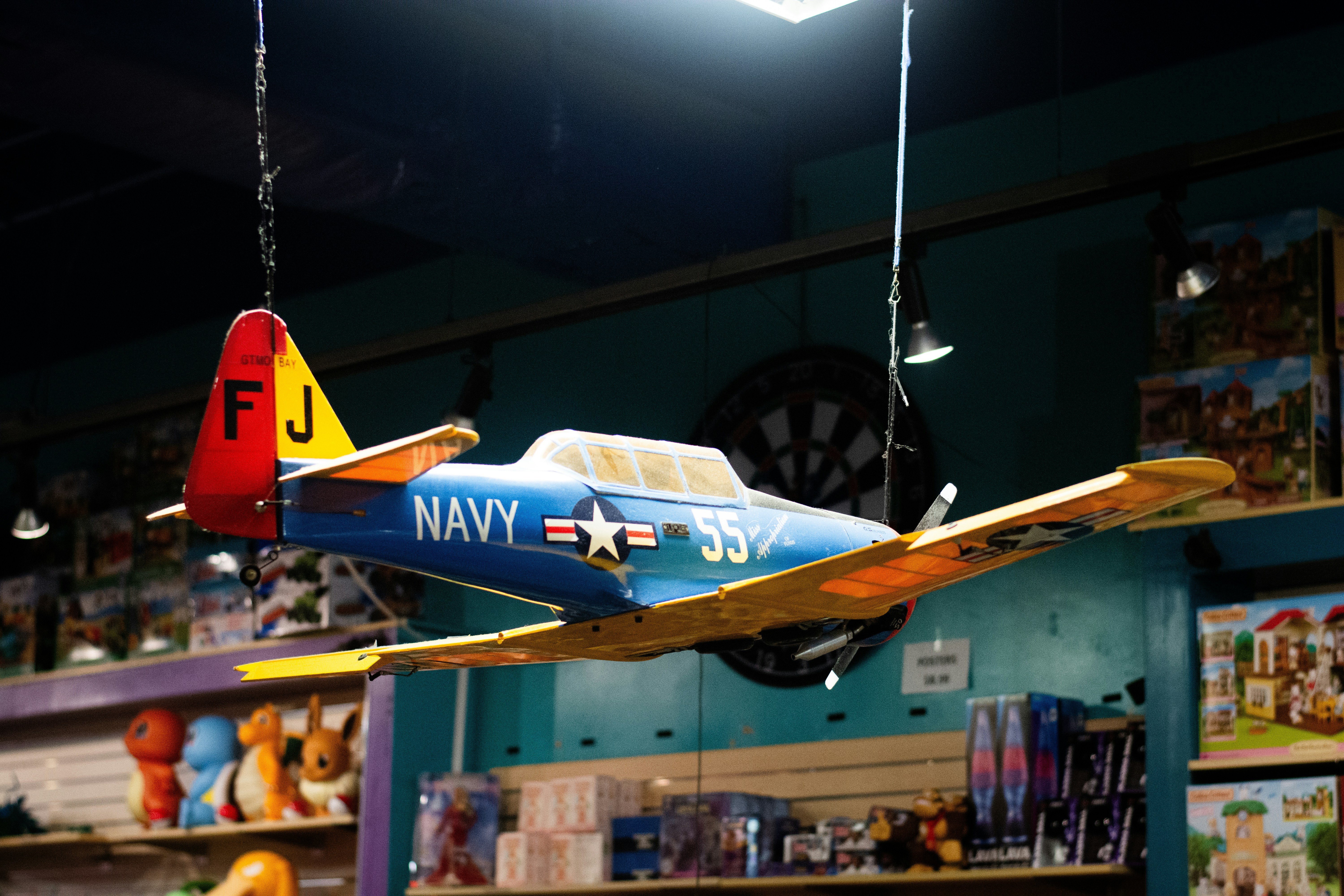 Suspended Blue Navy Trainer Model Hovering Over a Toy Store Display