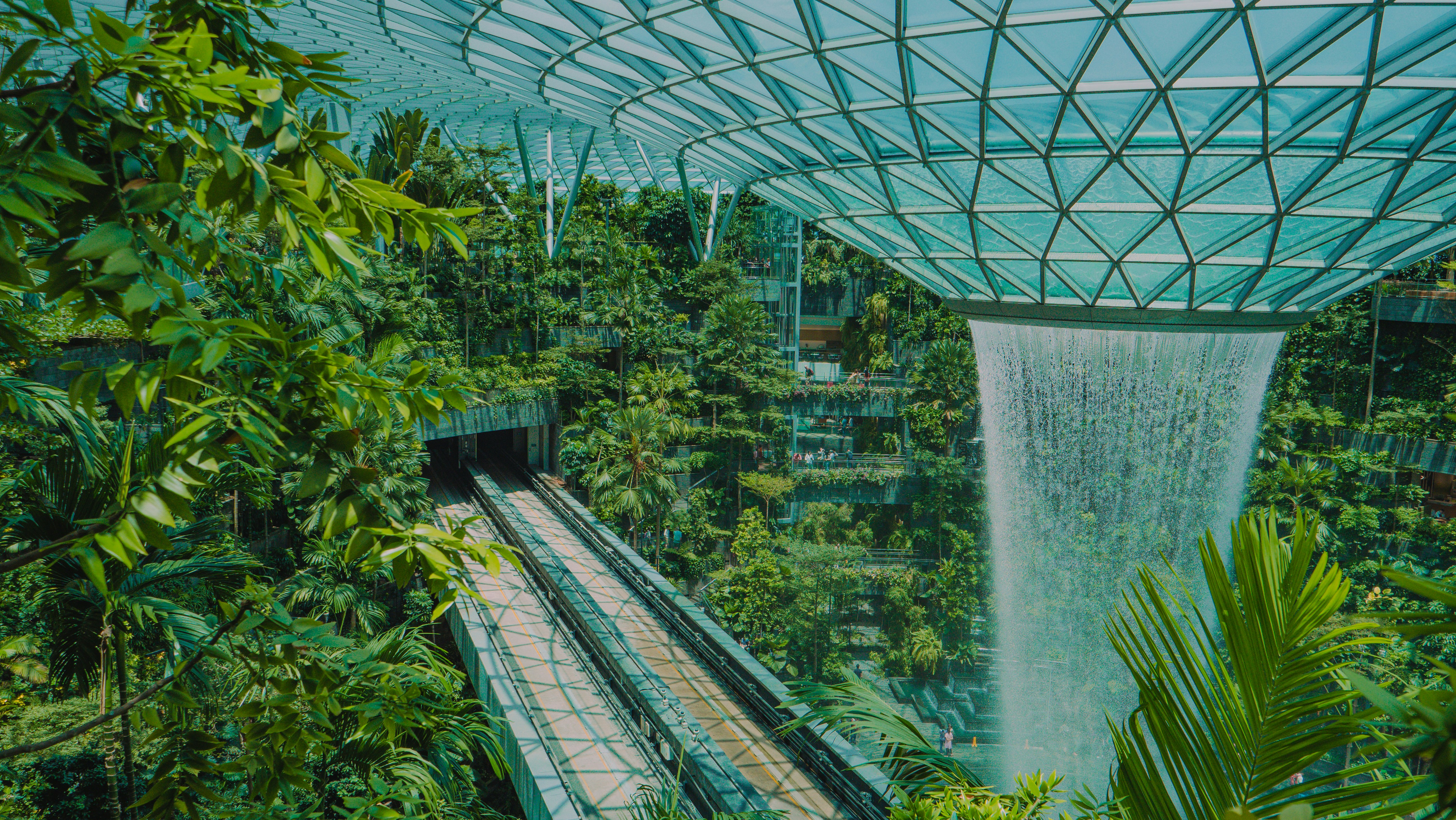 Verdant Cathedral: Glass-Canopy Atrium Framing a Cascading Fountain
