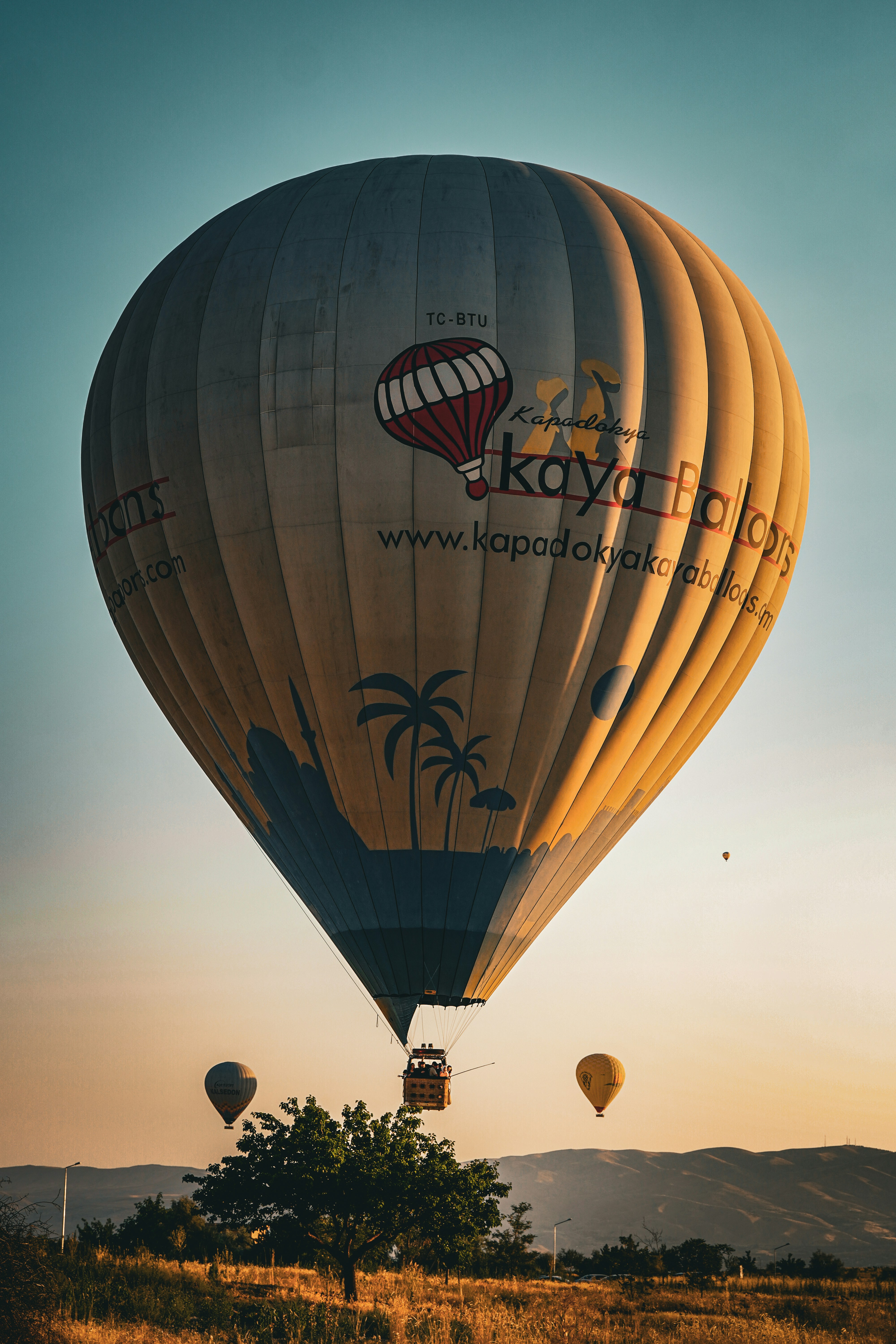 A hot air balloon floats among others in the sky.