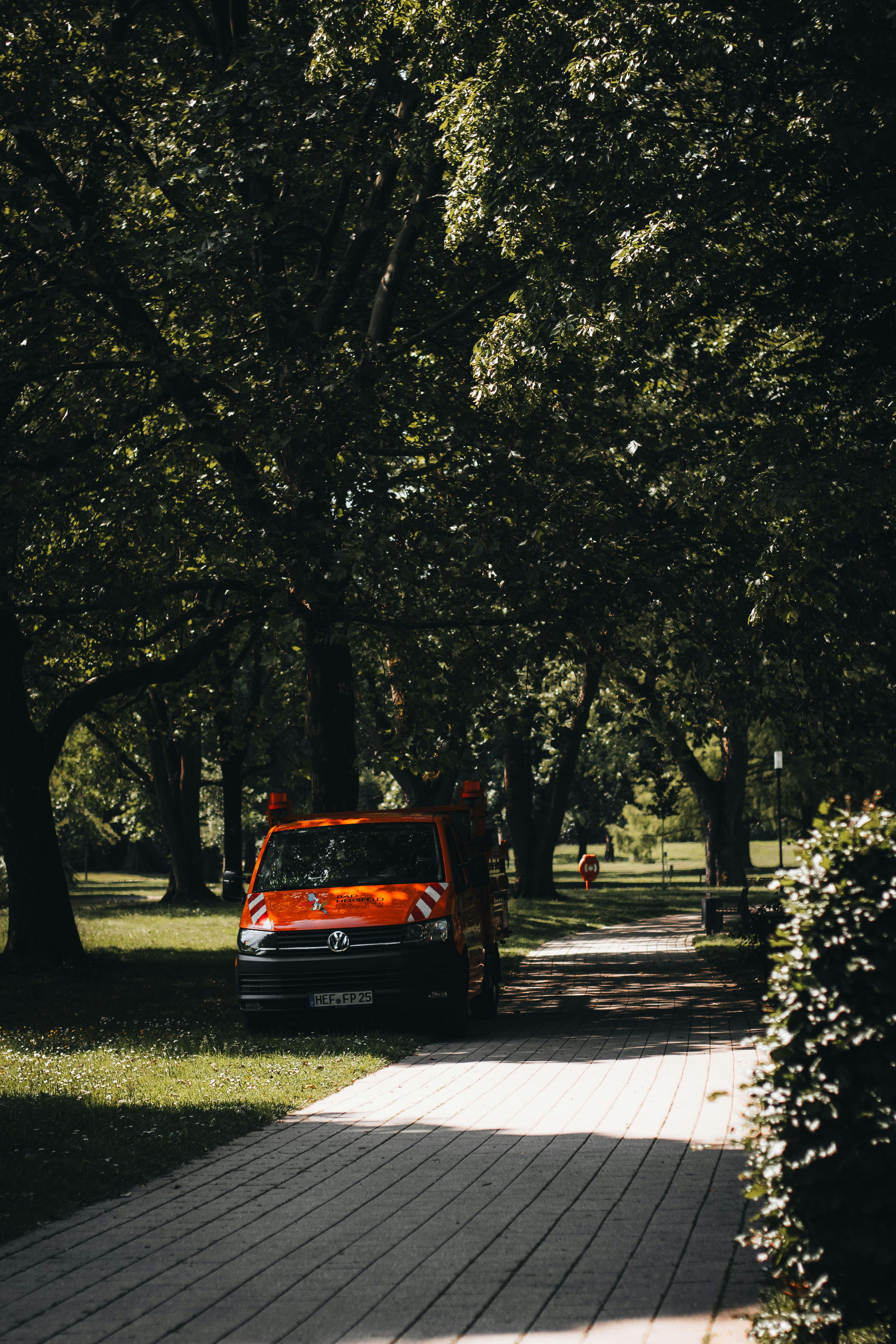 Orange Utility Vehicle in a Shaded Park Path