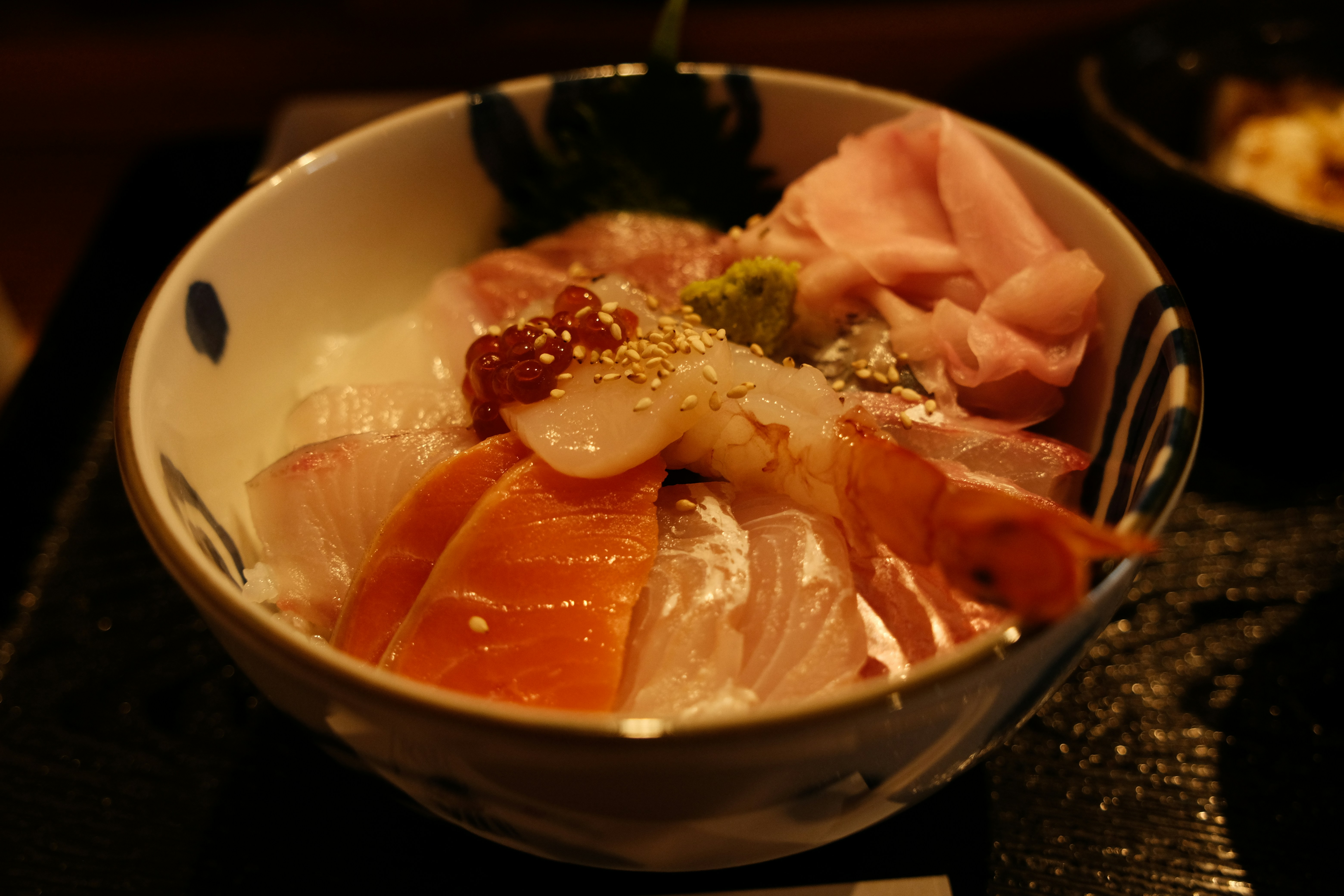 Amber-lit Sashimi Bowl: Close-Up of Tuna, Salmon, and White Fish