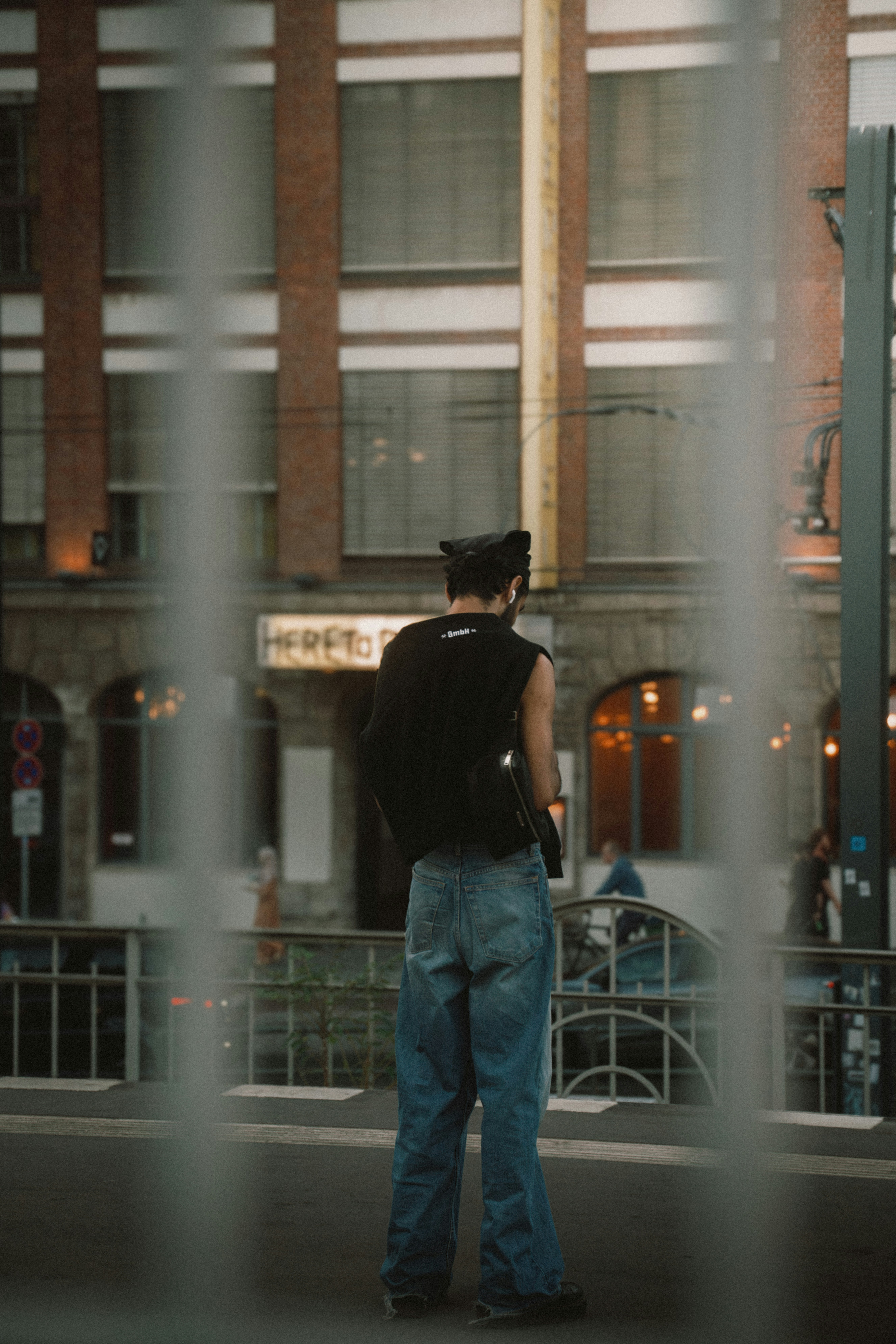 Waiting for the subway in Berlin. | A person stands in front of a brick building.