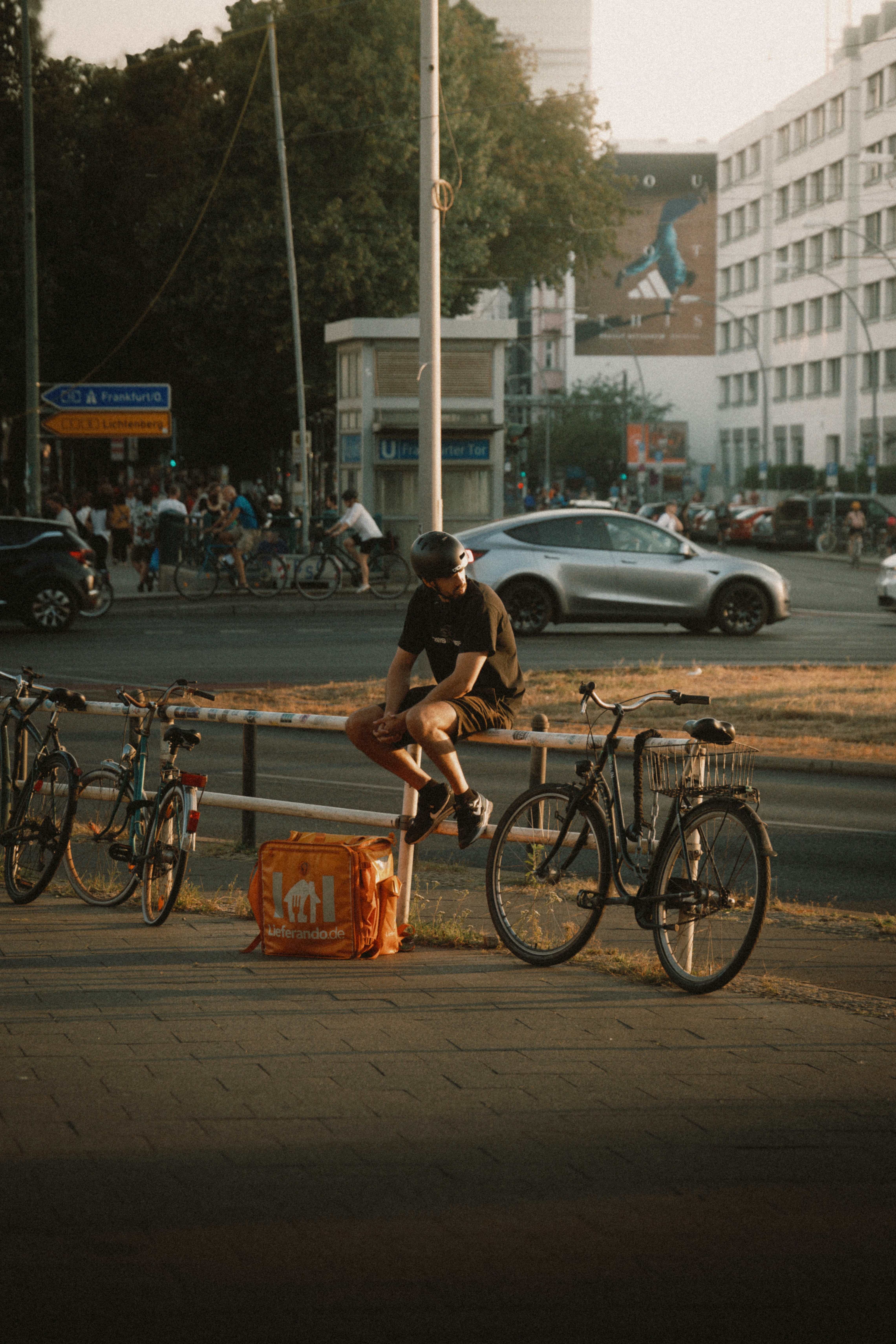A delivery rider rests on a city street.