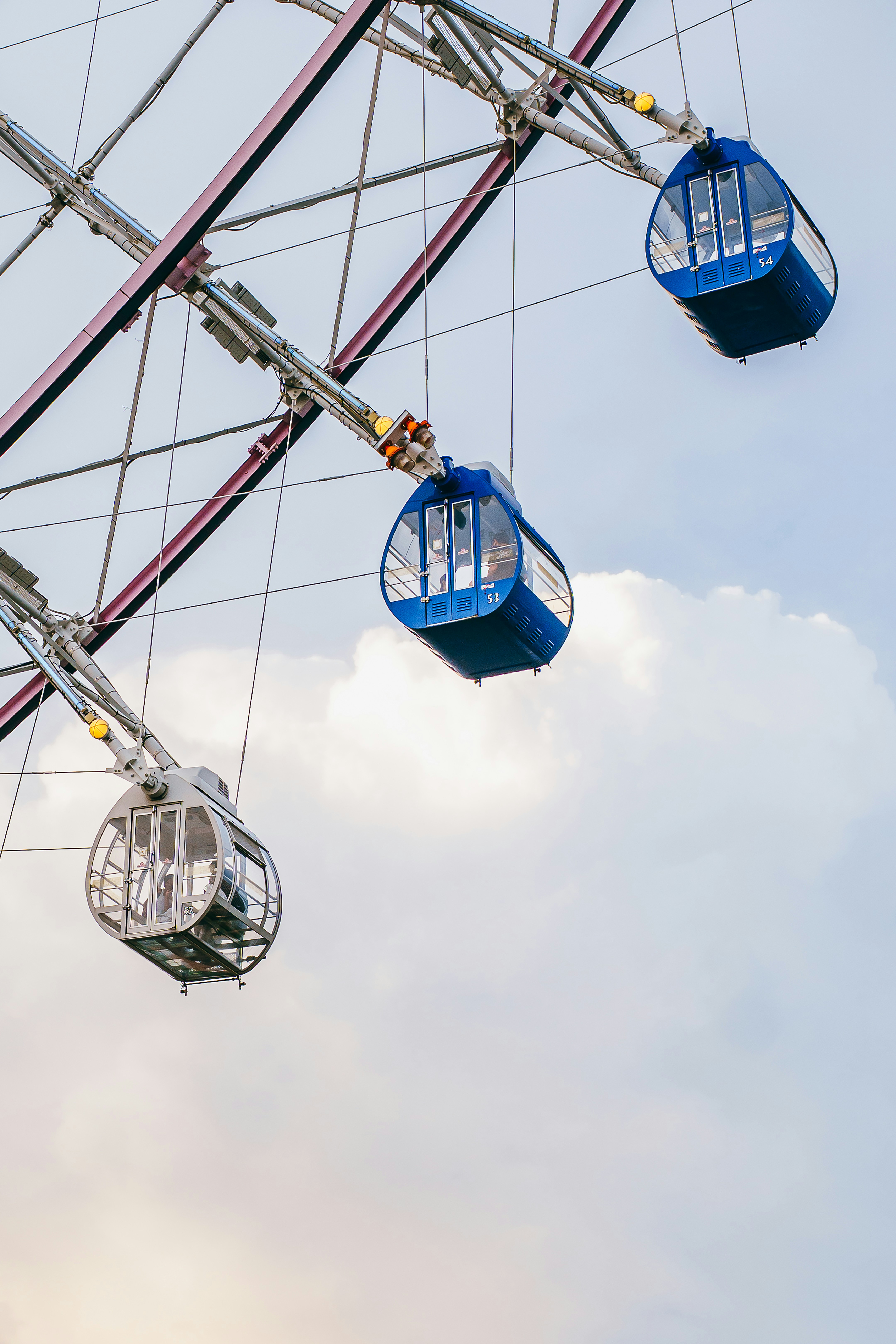 Ferris wheel pods against a cloudy sky.