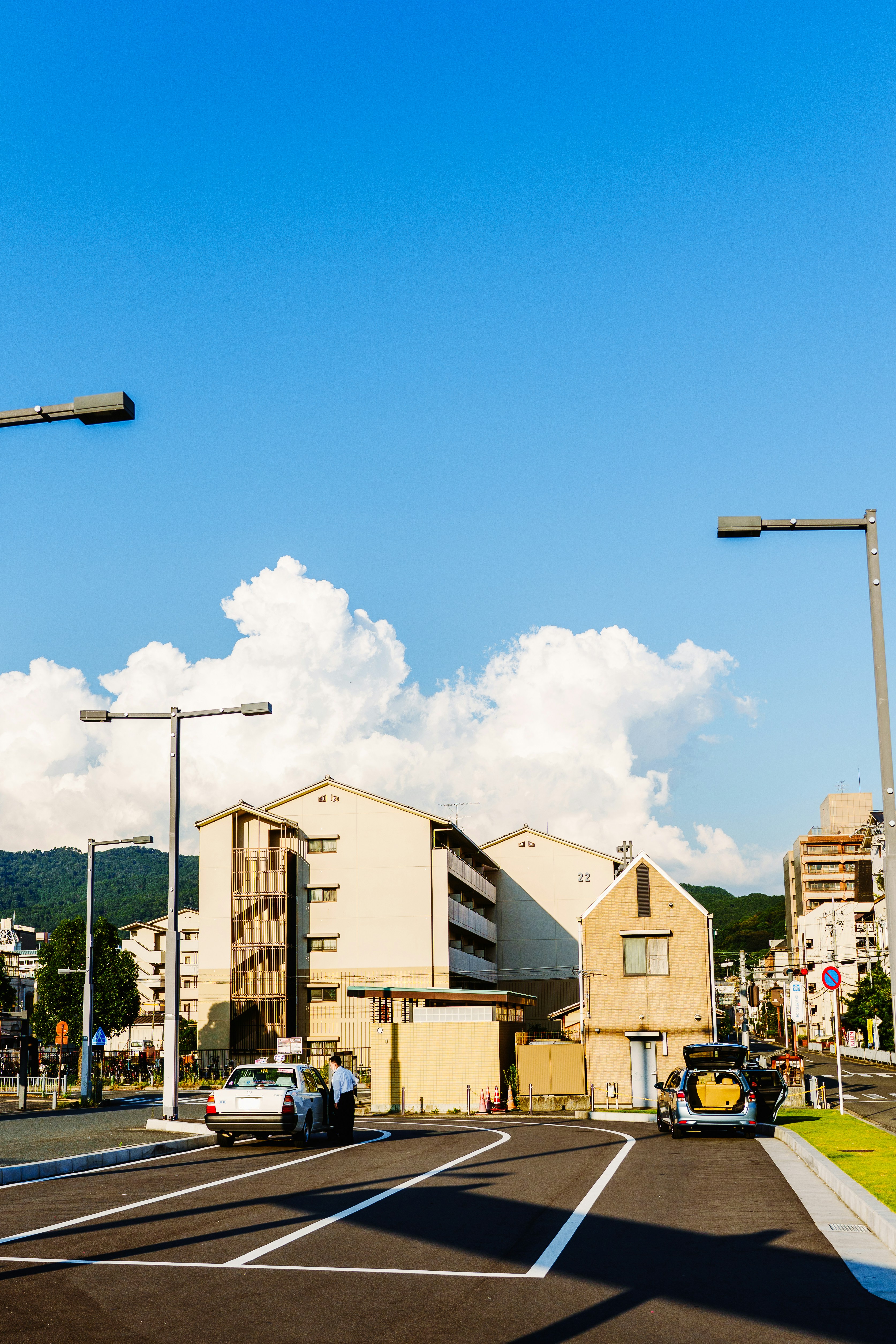 Cars at a road intersection with a bright blue sky.