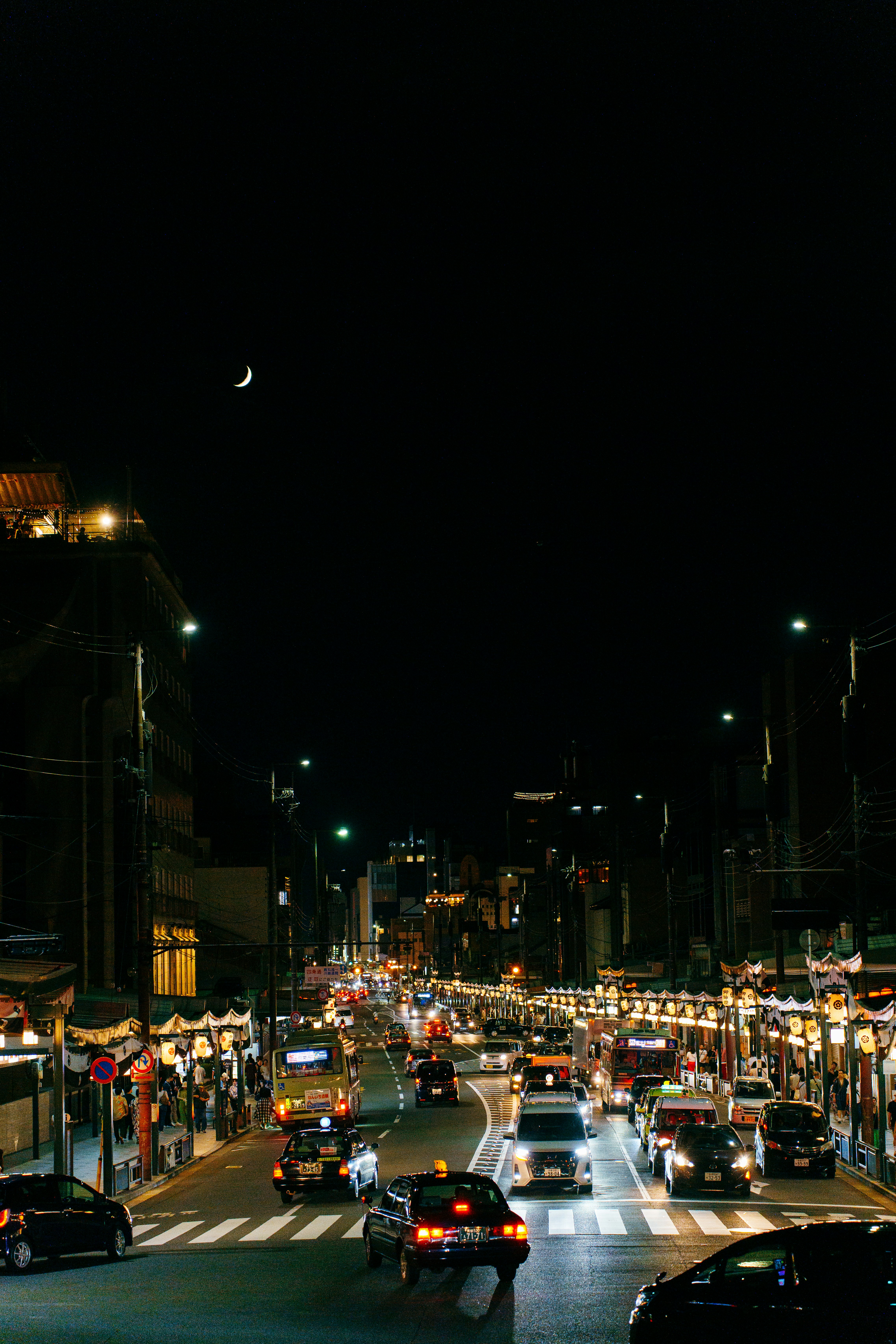 Nighttime traffic lights up a city street.