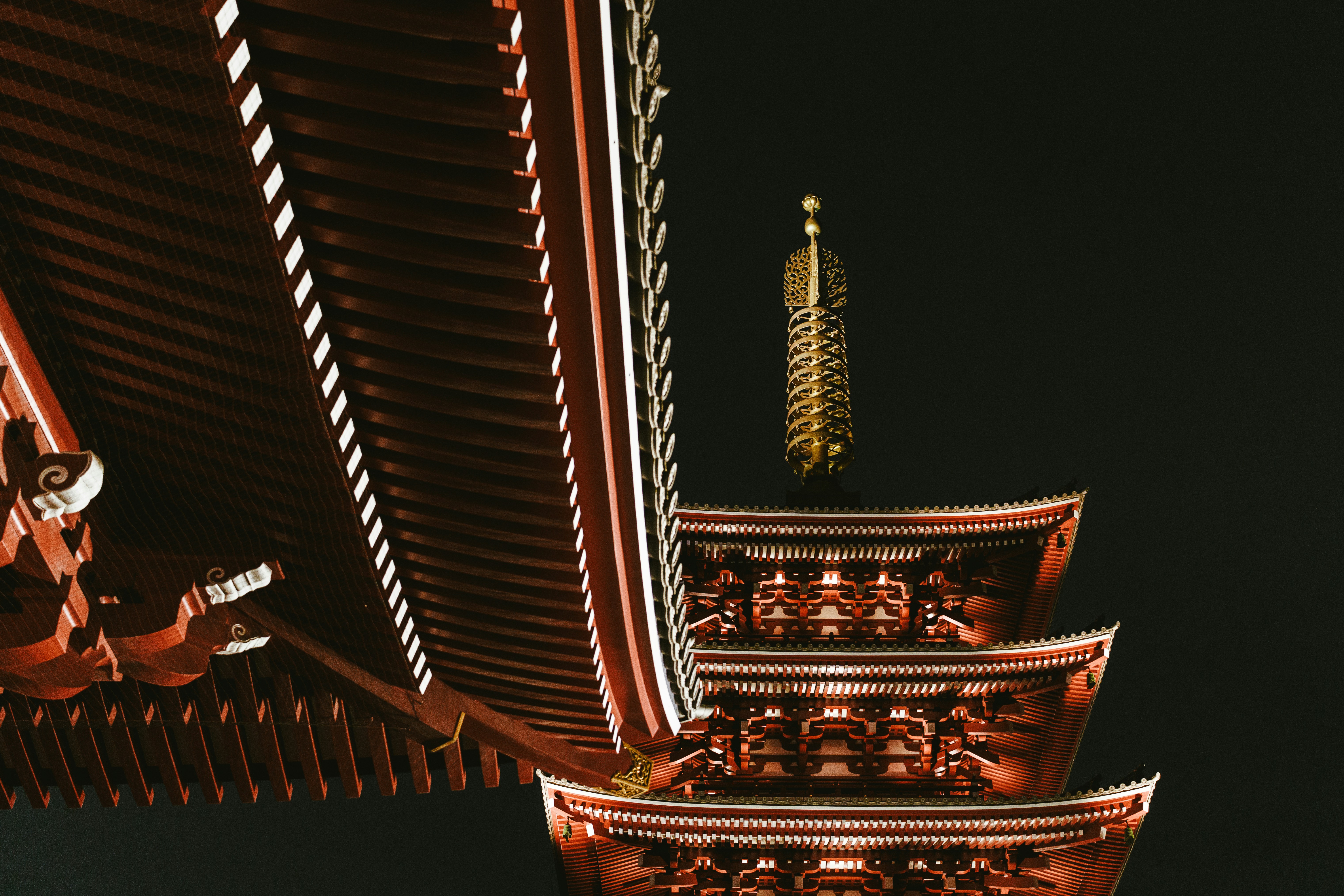 A red japanese pagoda, illuminated at night.
