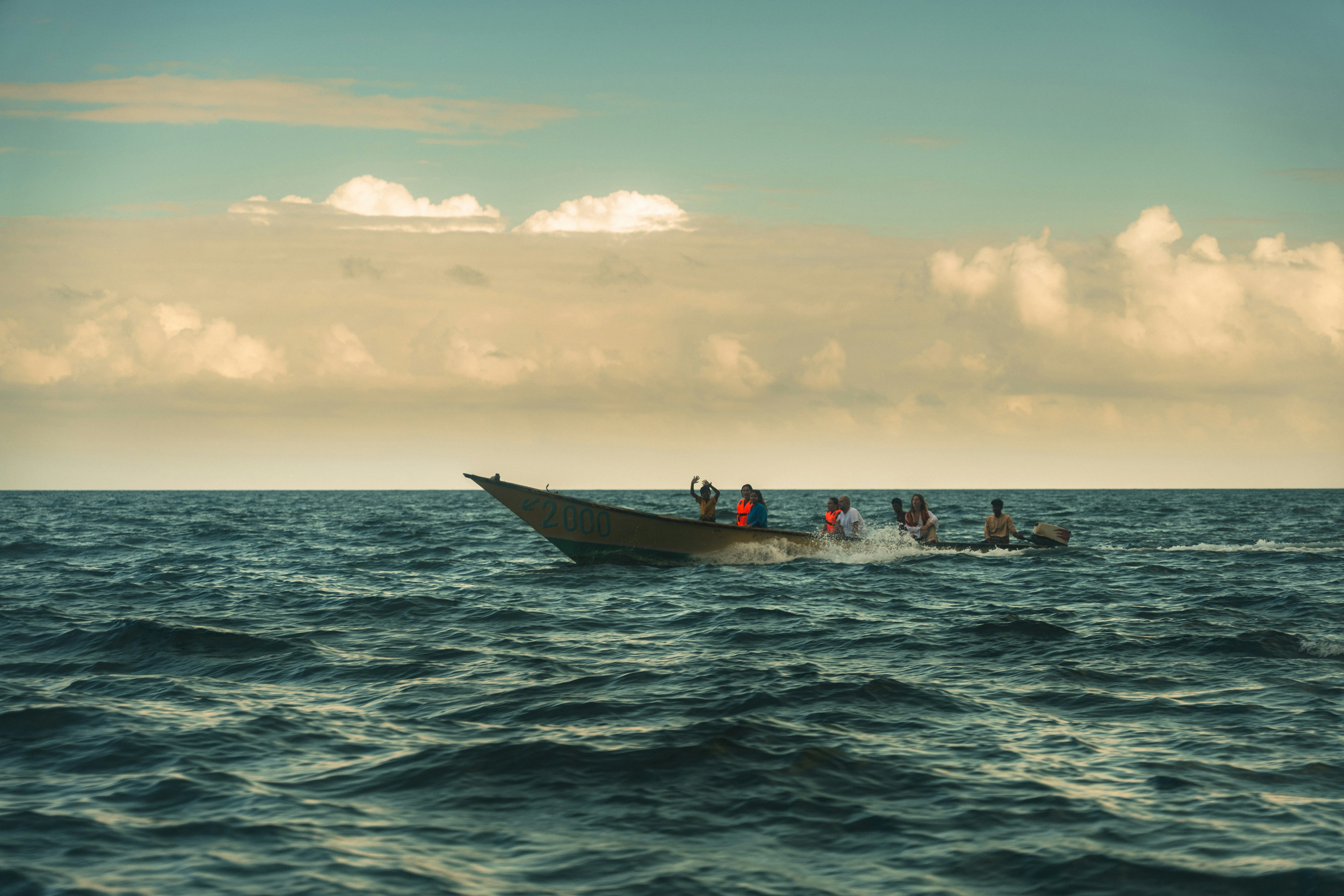 A boat speeds across the calm ocean.