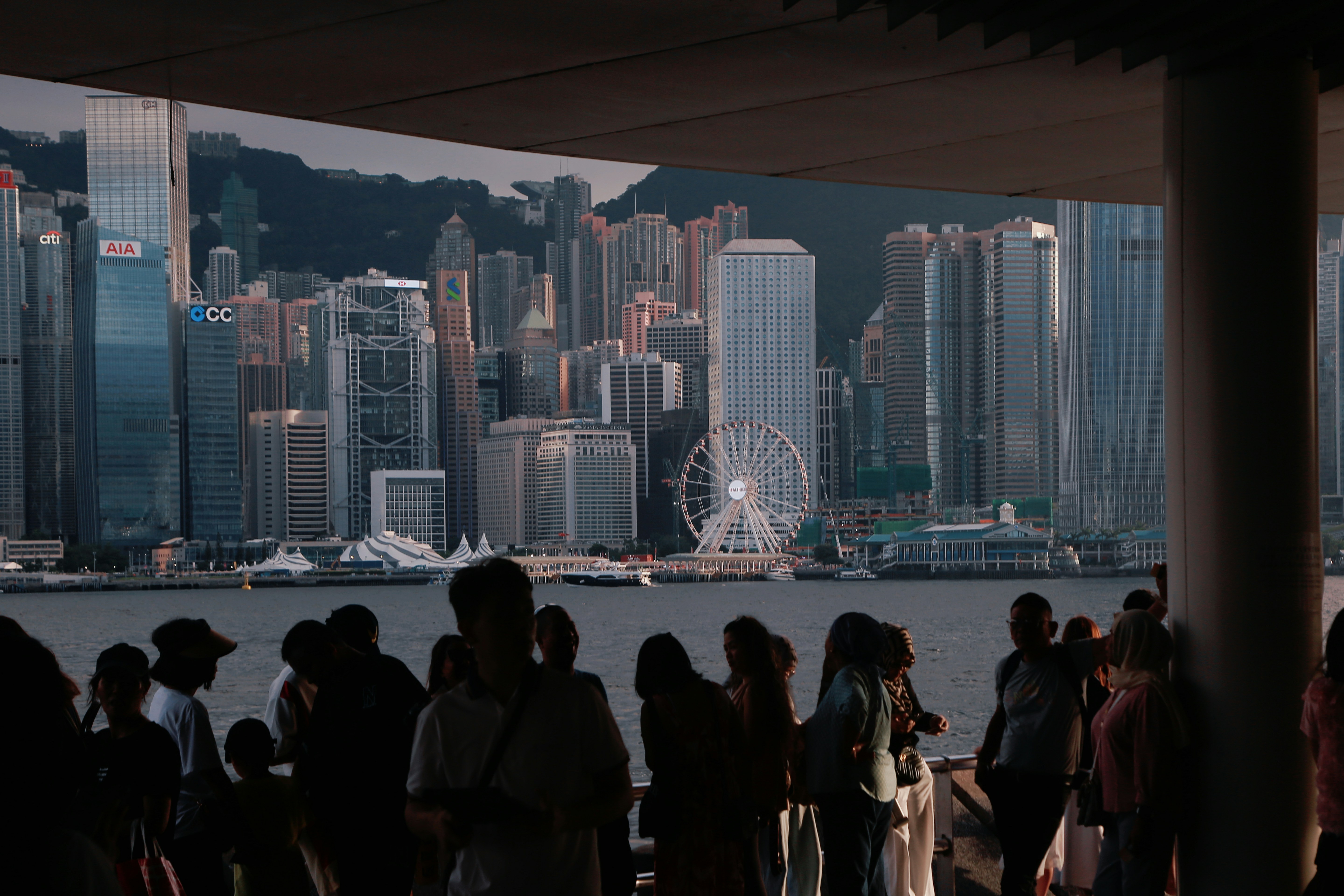 People gaze at a city skyline with an observation wheel. photo – Free ...