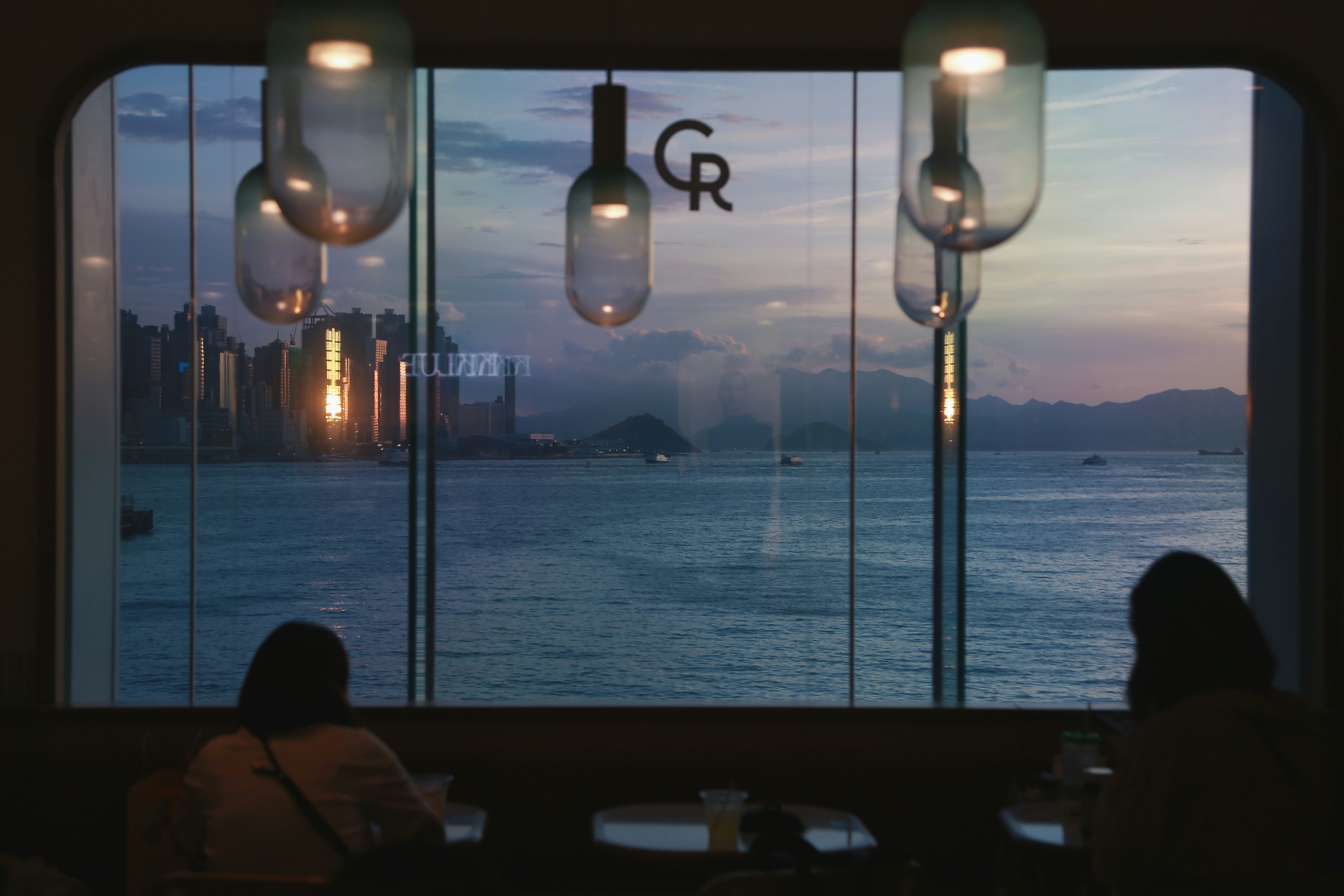 Restaurant diners enjoy waterfront view at sunset.