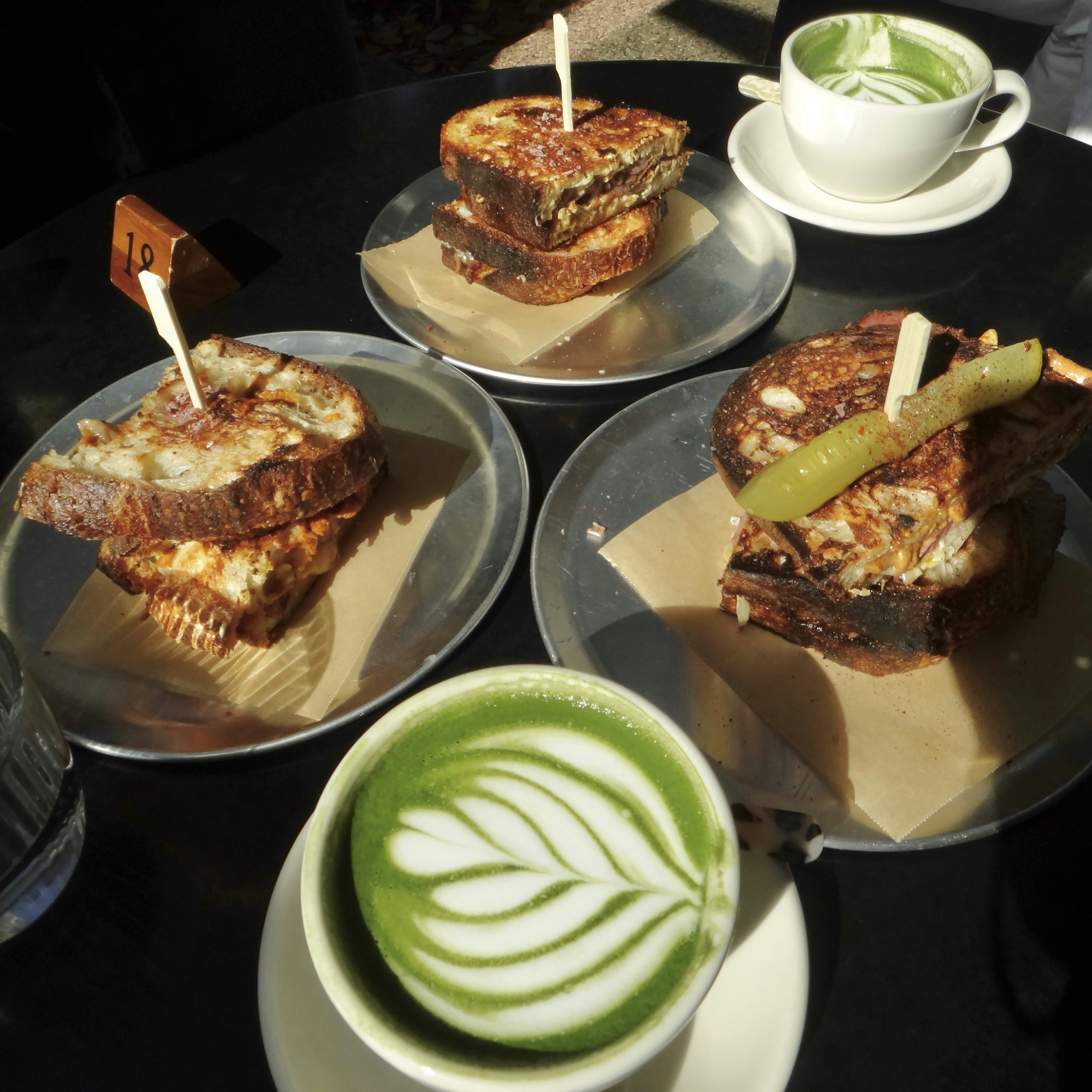 Grilled sandwiches and matcha latte are featured.