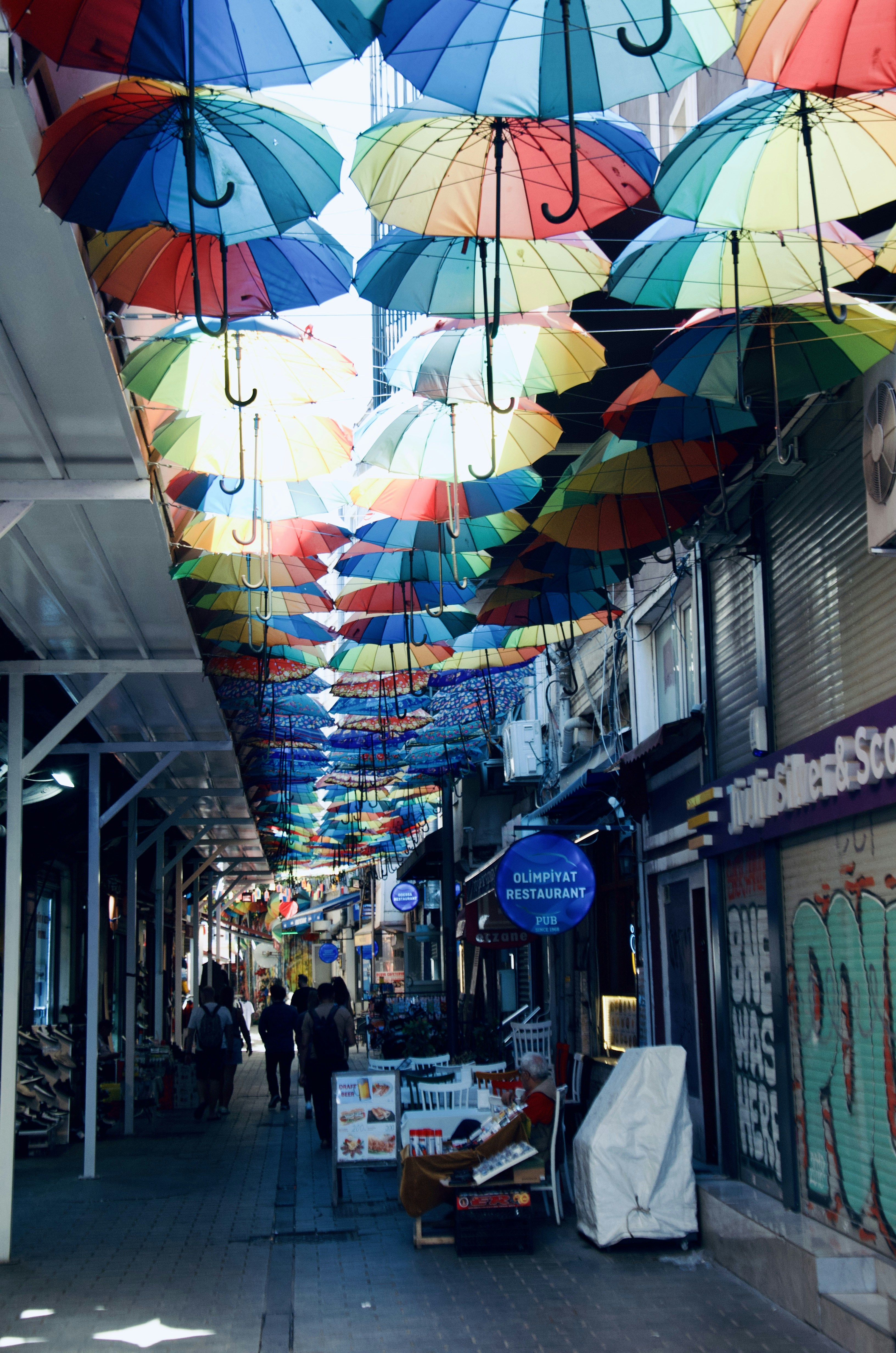 Colorful umbrellas decorate a narrow street.