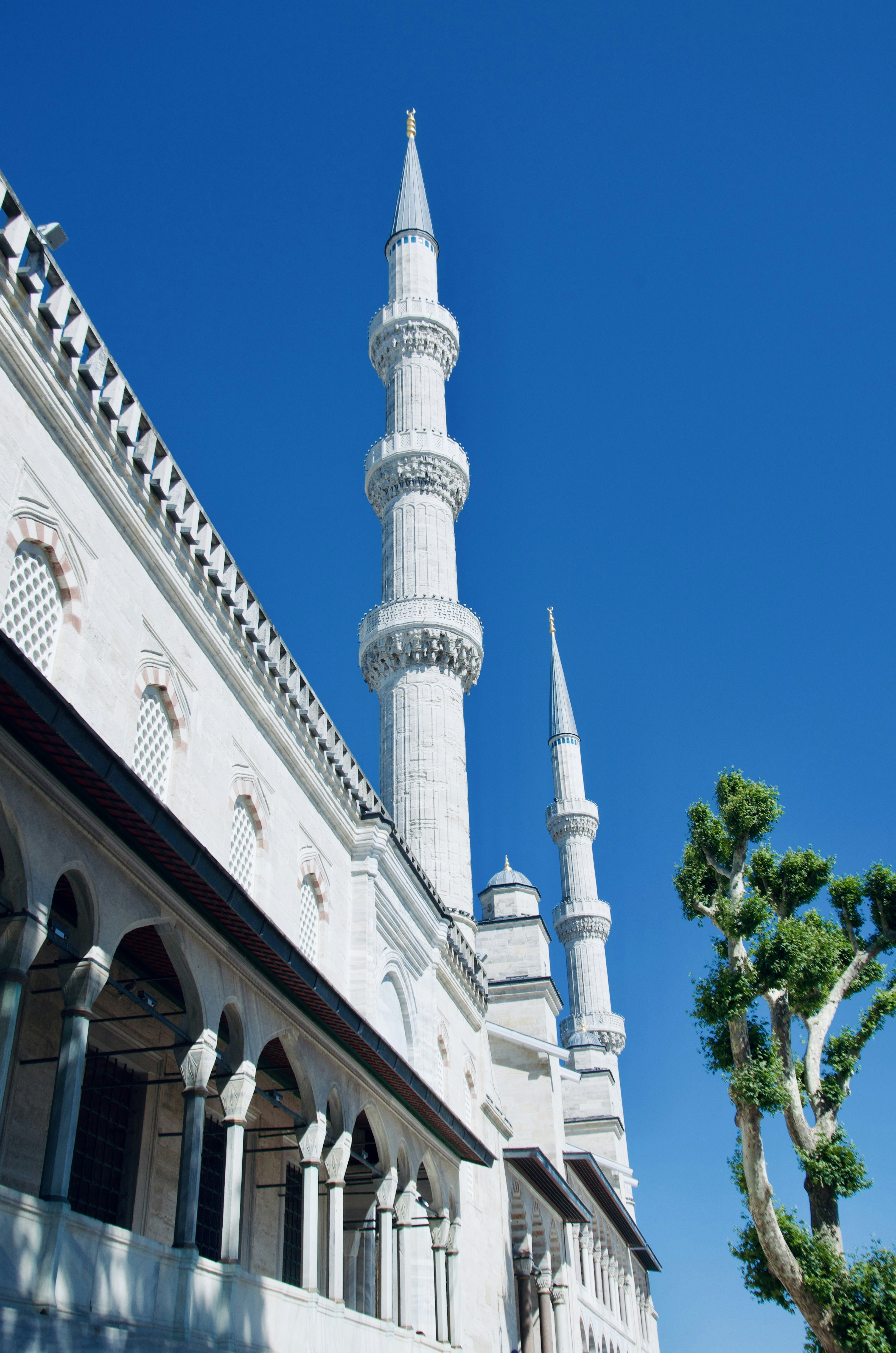 A mosque with tall minarets against blue sky.