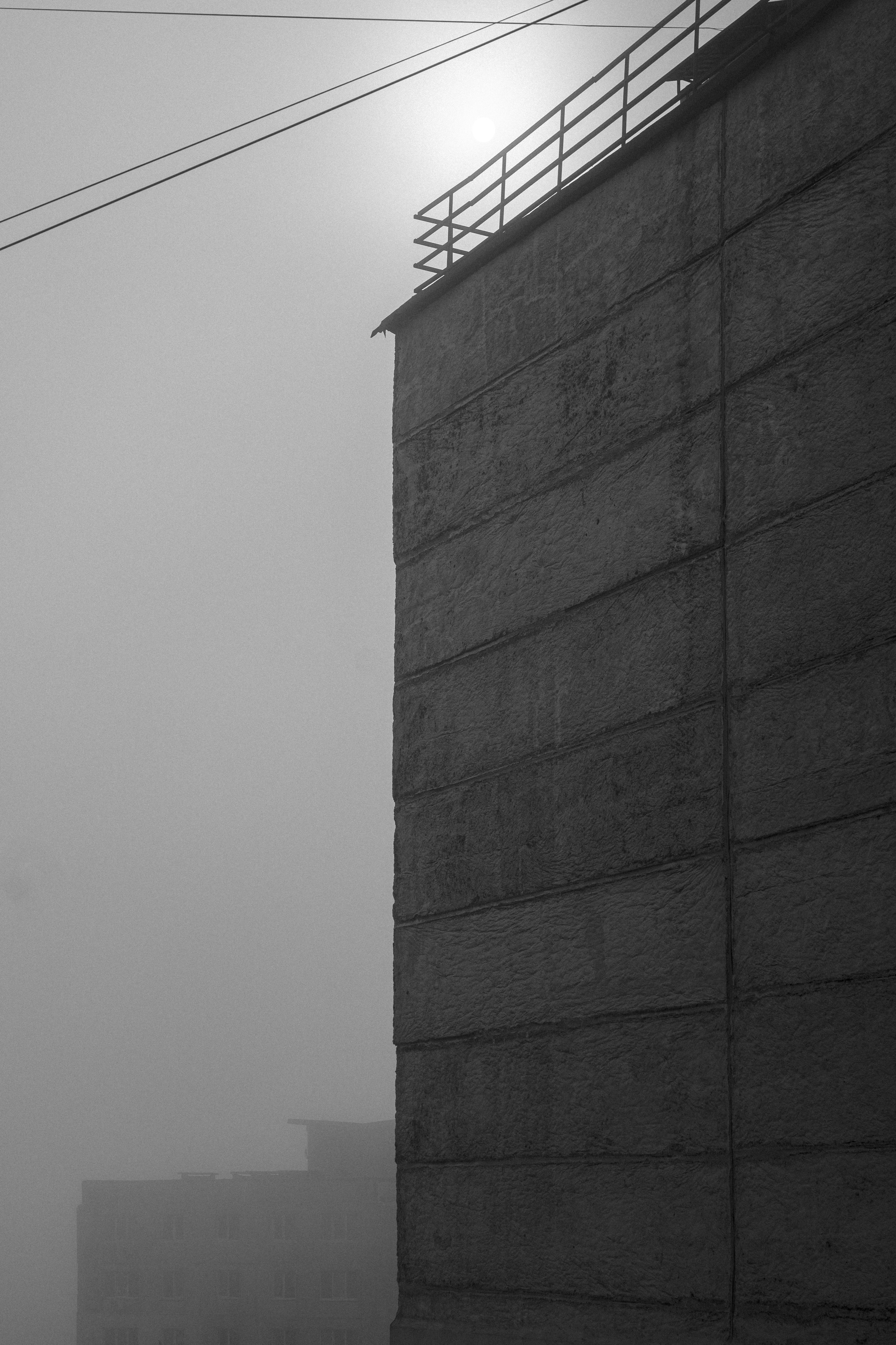 Street geometry - wall of a house, fog and barely visible sunshine | Foggy building silhouette with lines.