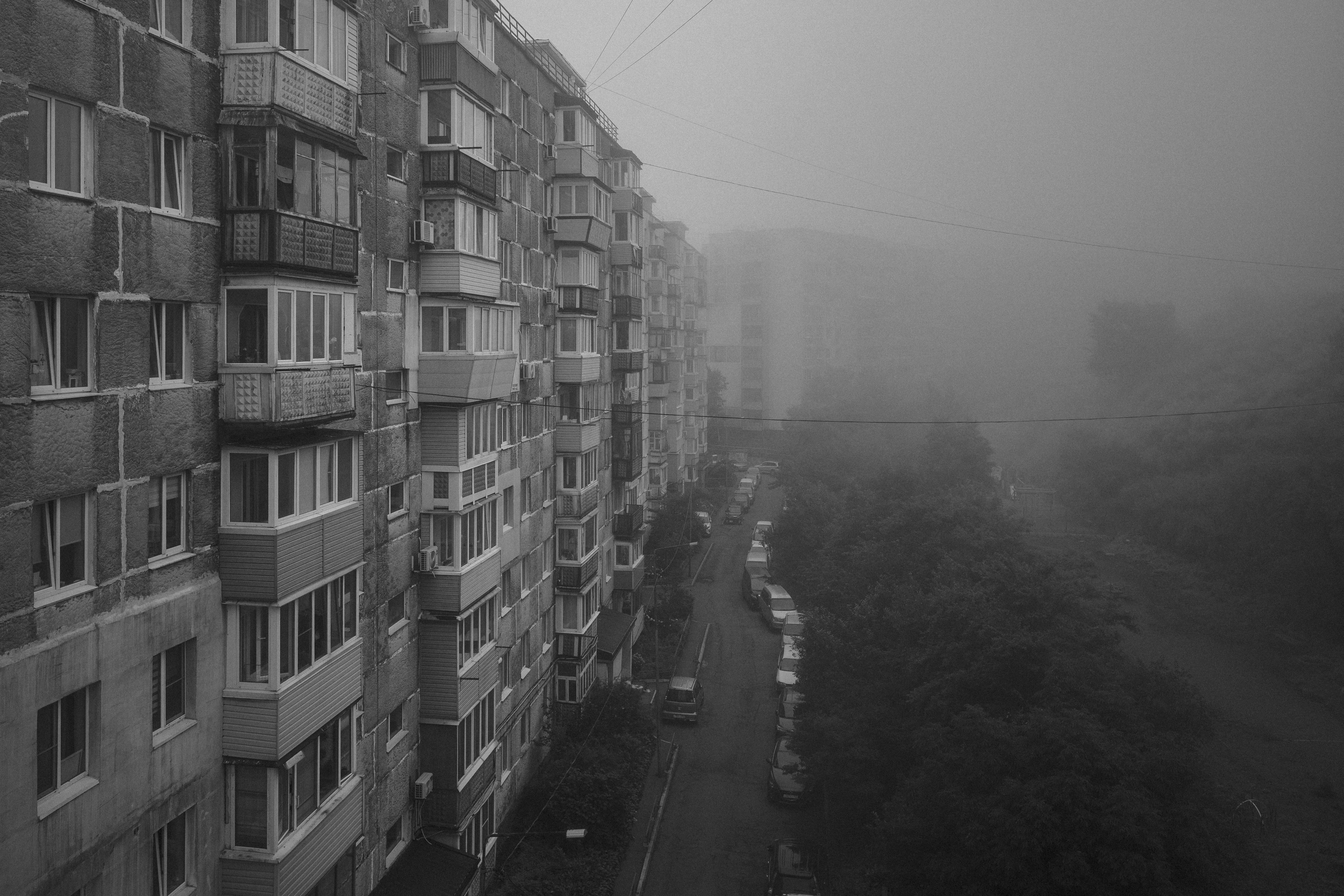 A dormitory district of the port city in the fog | Apartment building in the fog during a grey day.