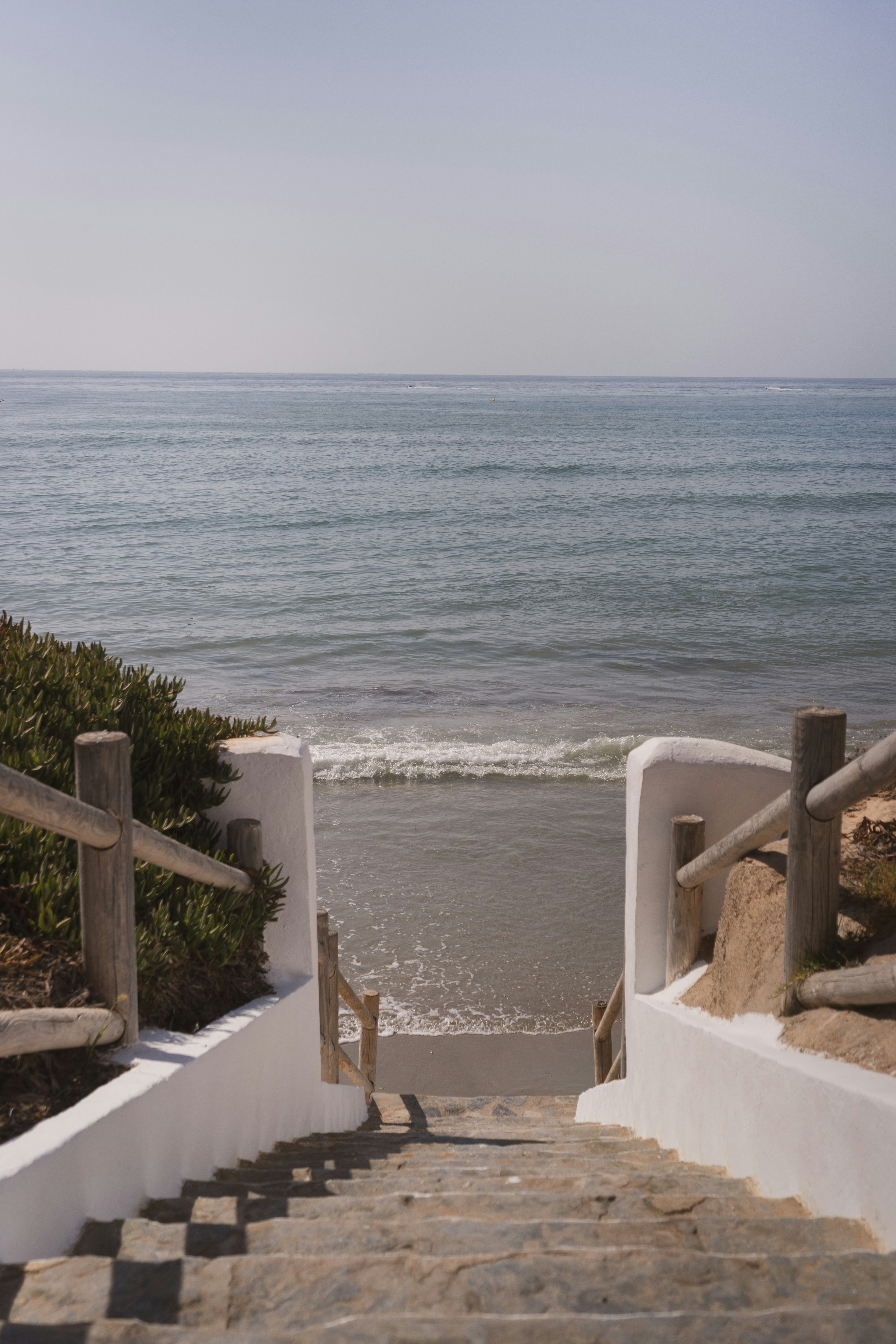 Photo of a beach stairs. | Stairs lead down to a serene beach.