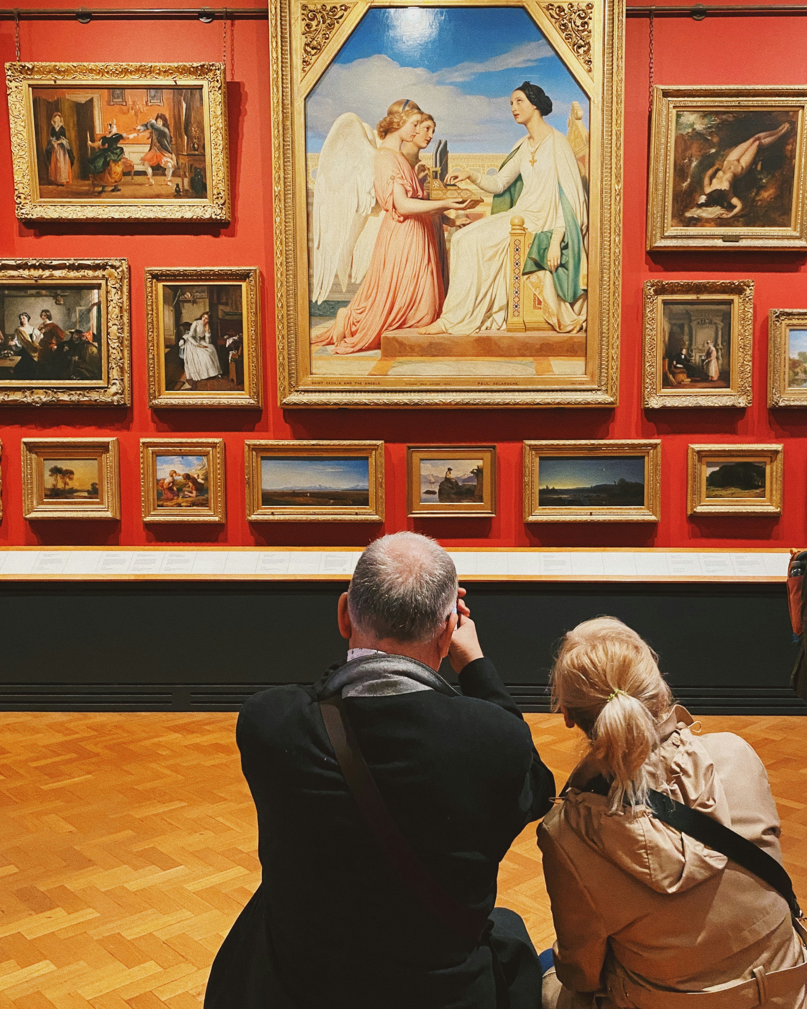 People admiring paintings in an art museum.
