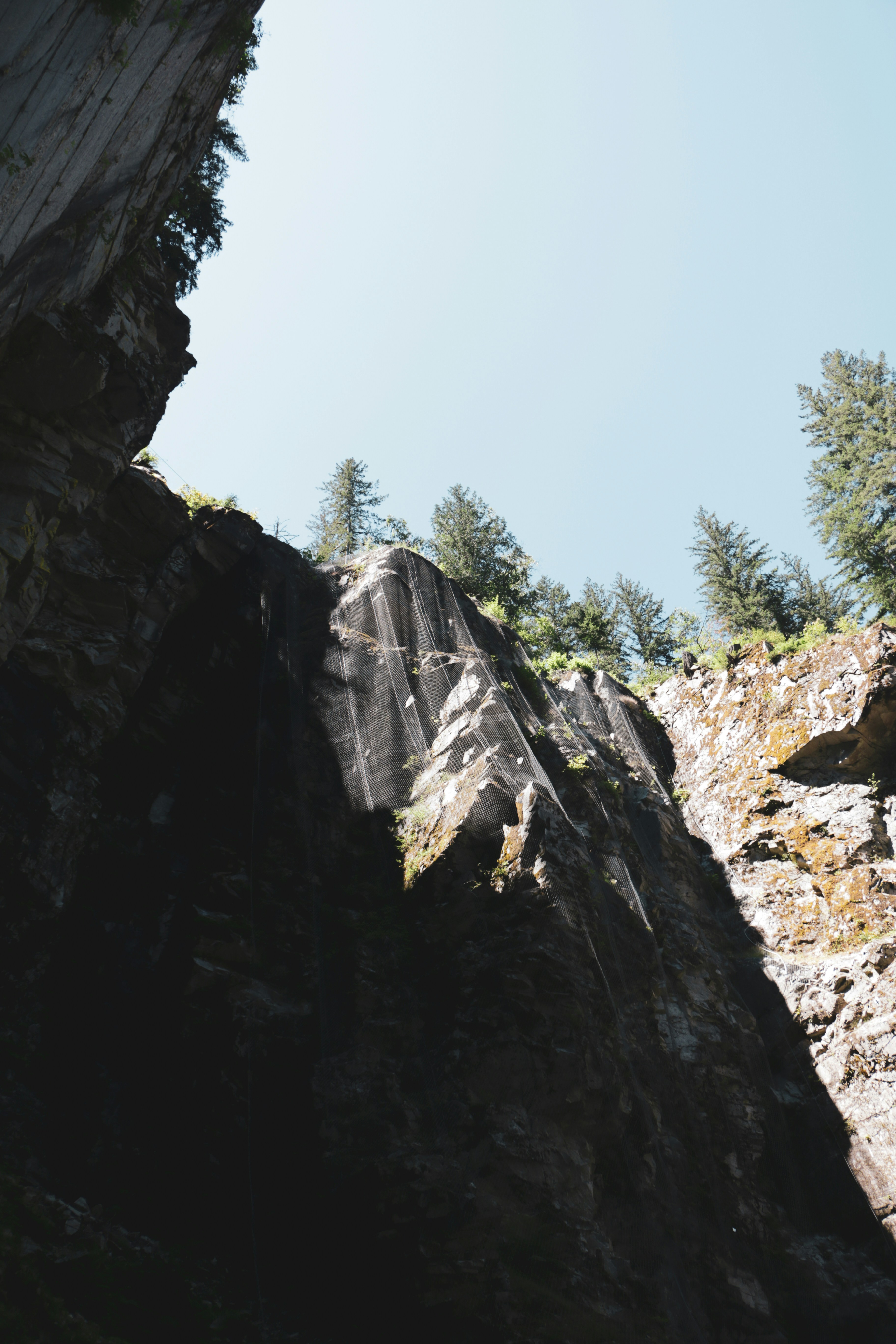 Dark cliffs rise with a clear sky above.